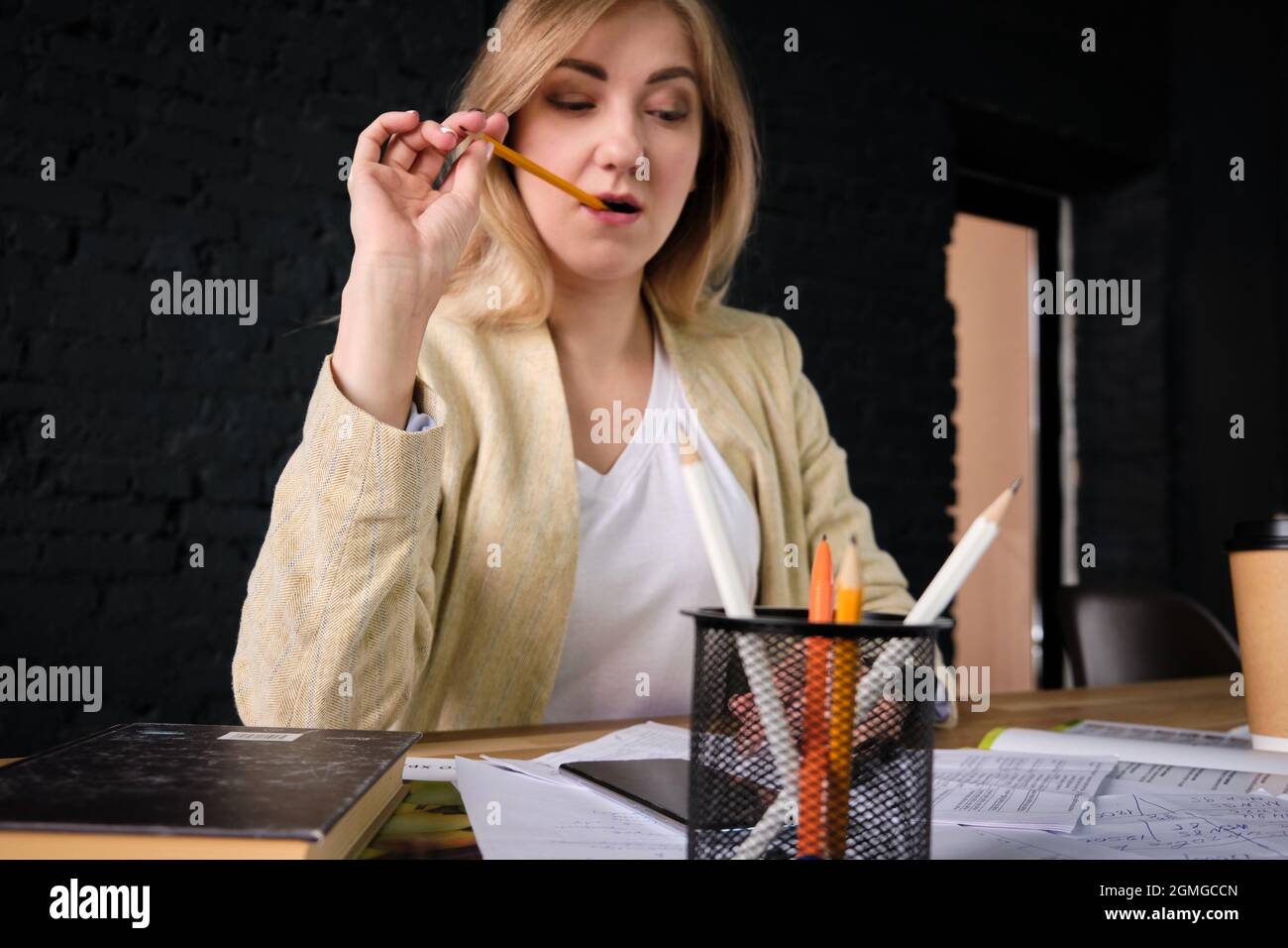 Young woman biting pen hi-res stock photography and images - Alamy