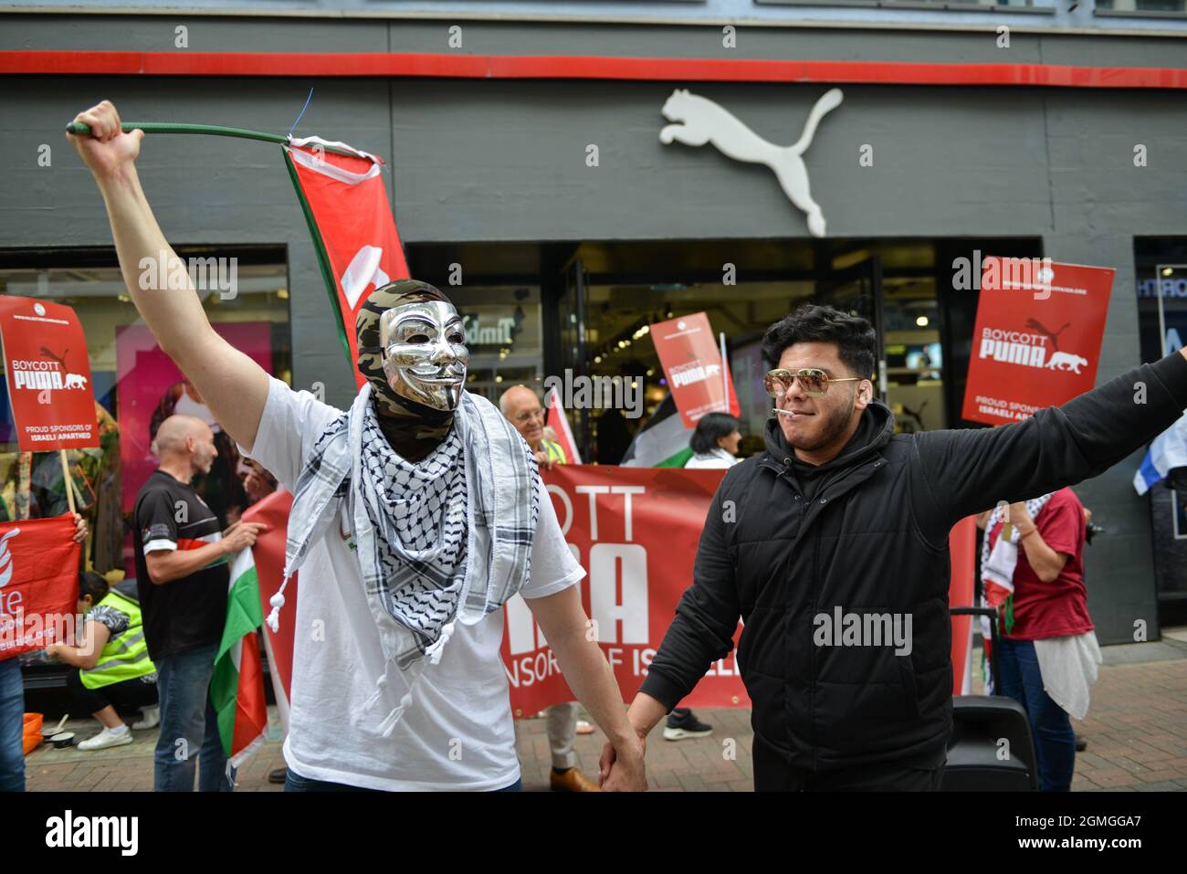 A protestor wearing a Guy Fawkes mask waves a flag, during the ...