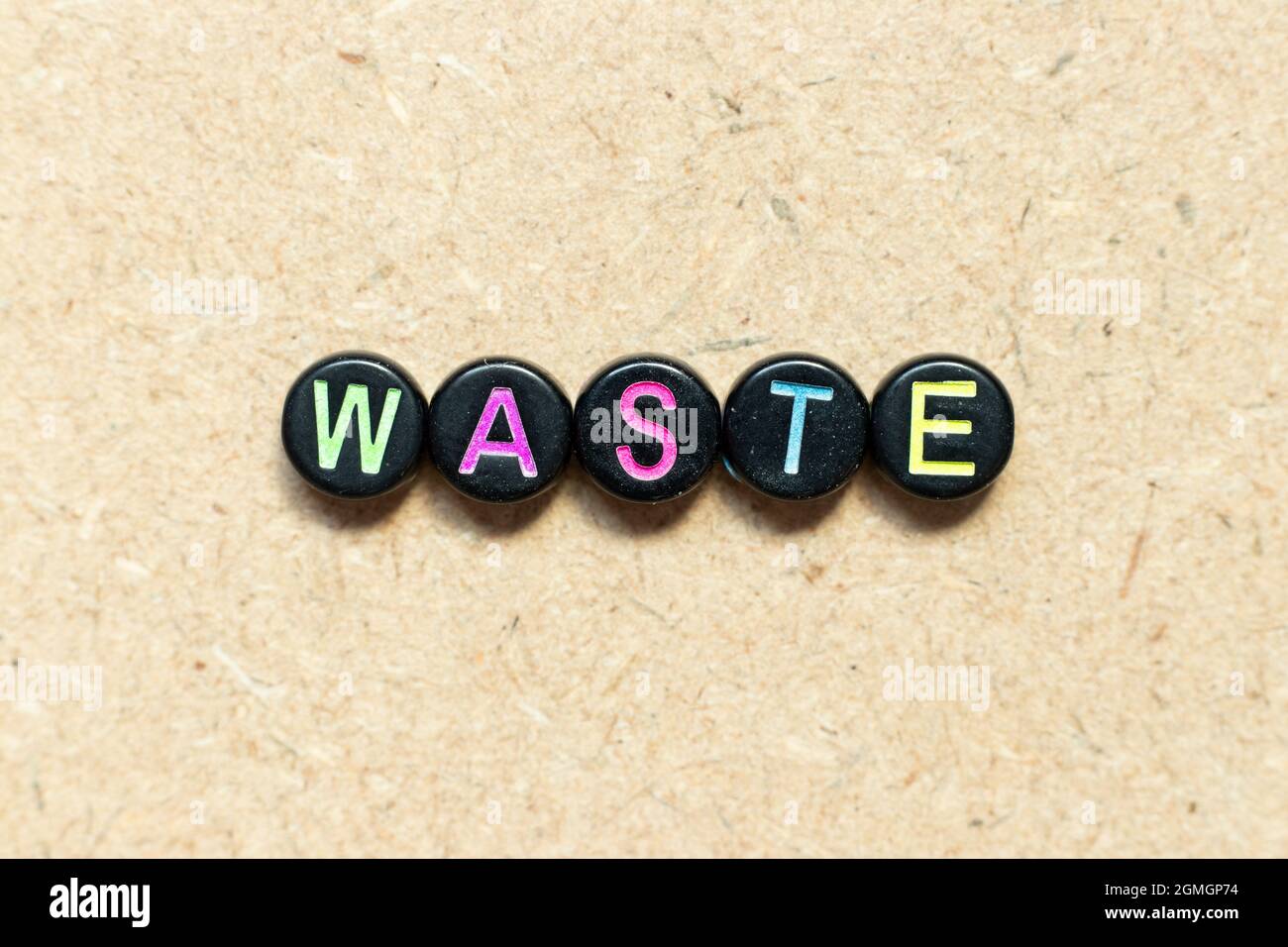 Black color round bead in word waste on wood background Stock Photo - Alamy