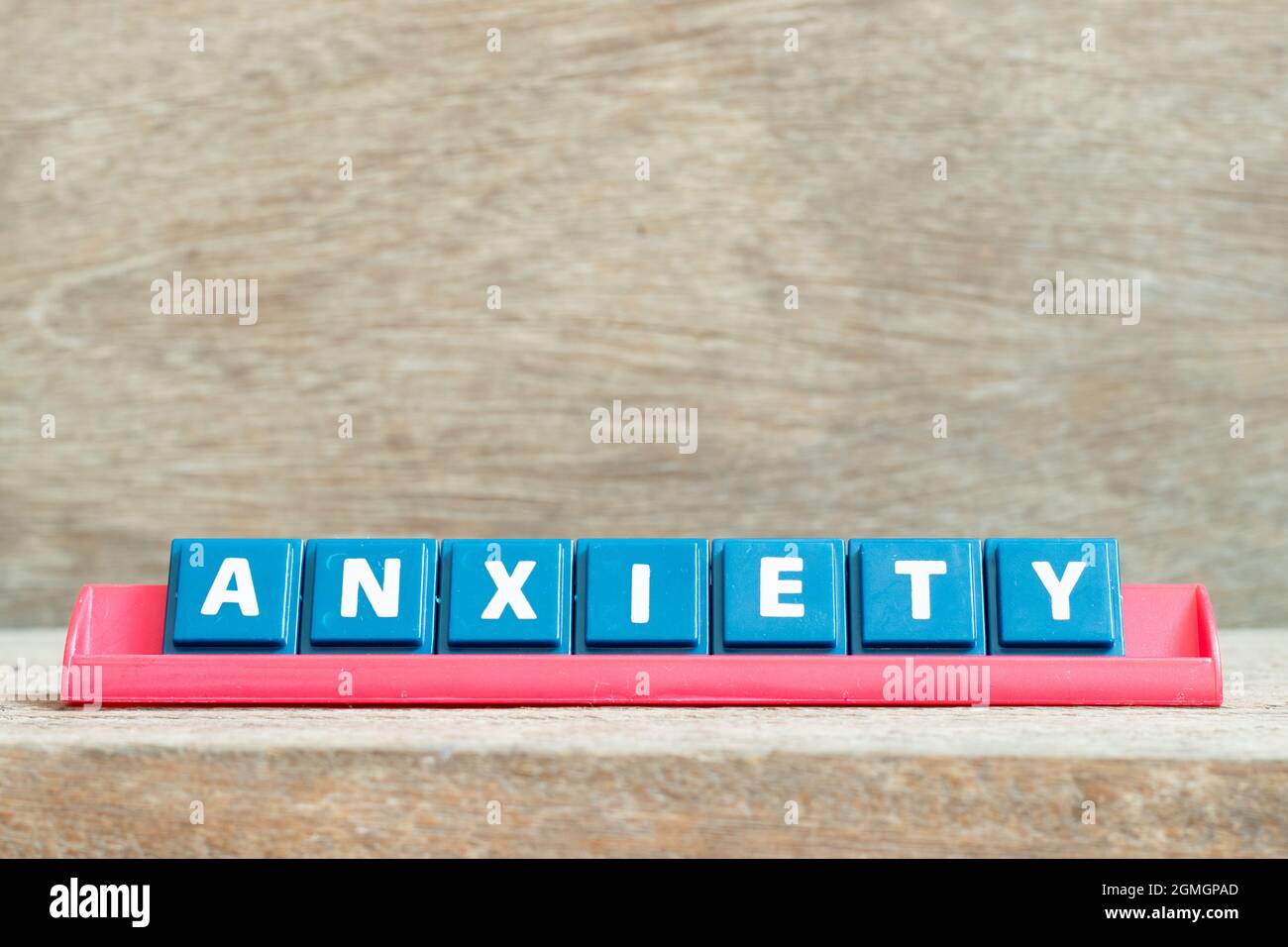 Tile alphabet letter with word anxiety in red color rack on wood ...