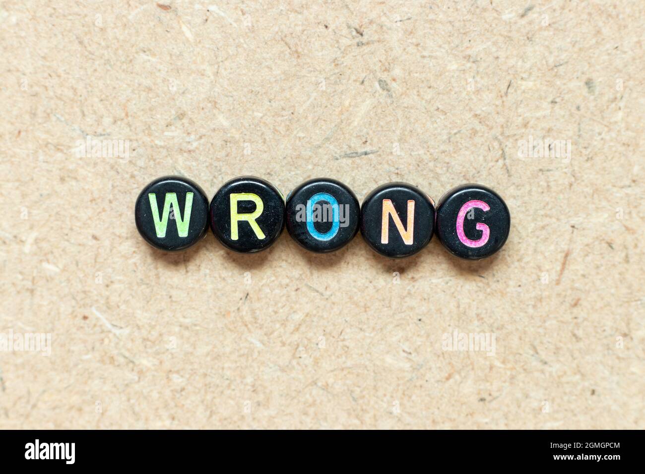 Black color round bead in word wrong on wood background Stock Photo - Alamy