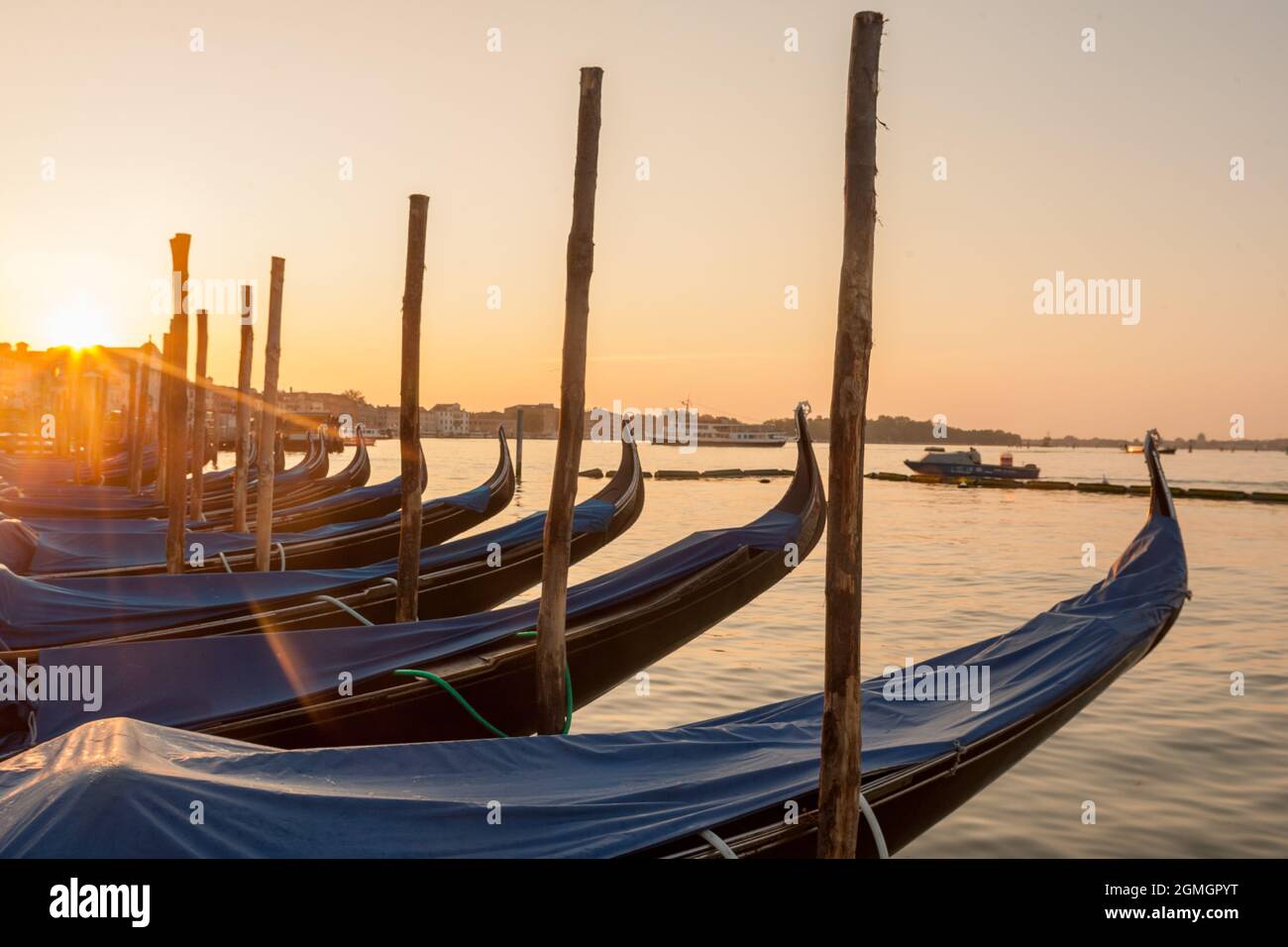 The sun rising over the grand canal in Venice, Italy causes a sunflare ...