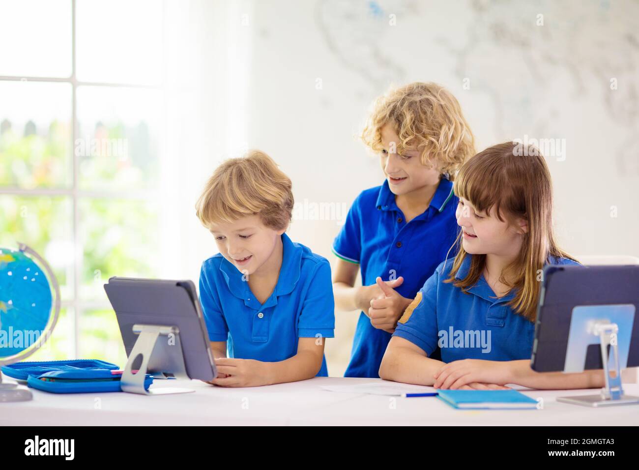 Online remote learning. School kids with computer having video ...