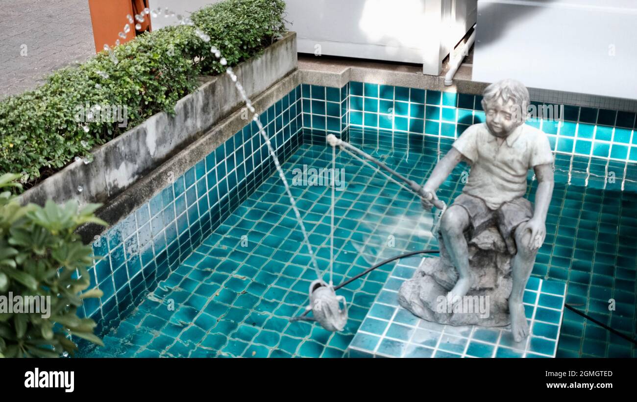 Statue of a man fishing in Pool Spitting Water on Soi Chit Lom Bangkok ...