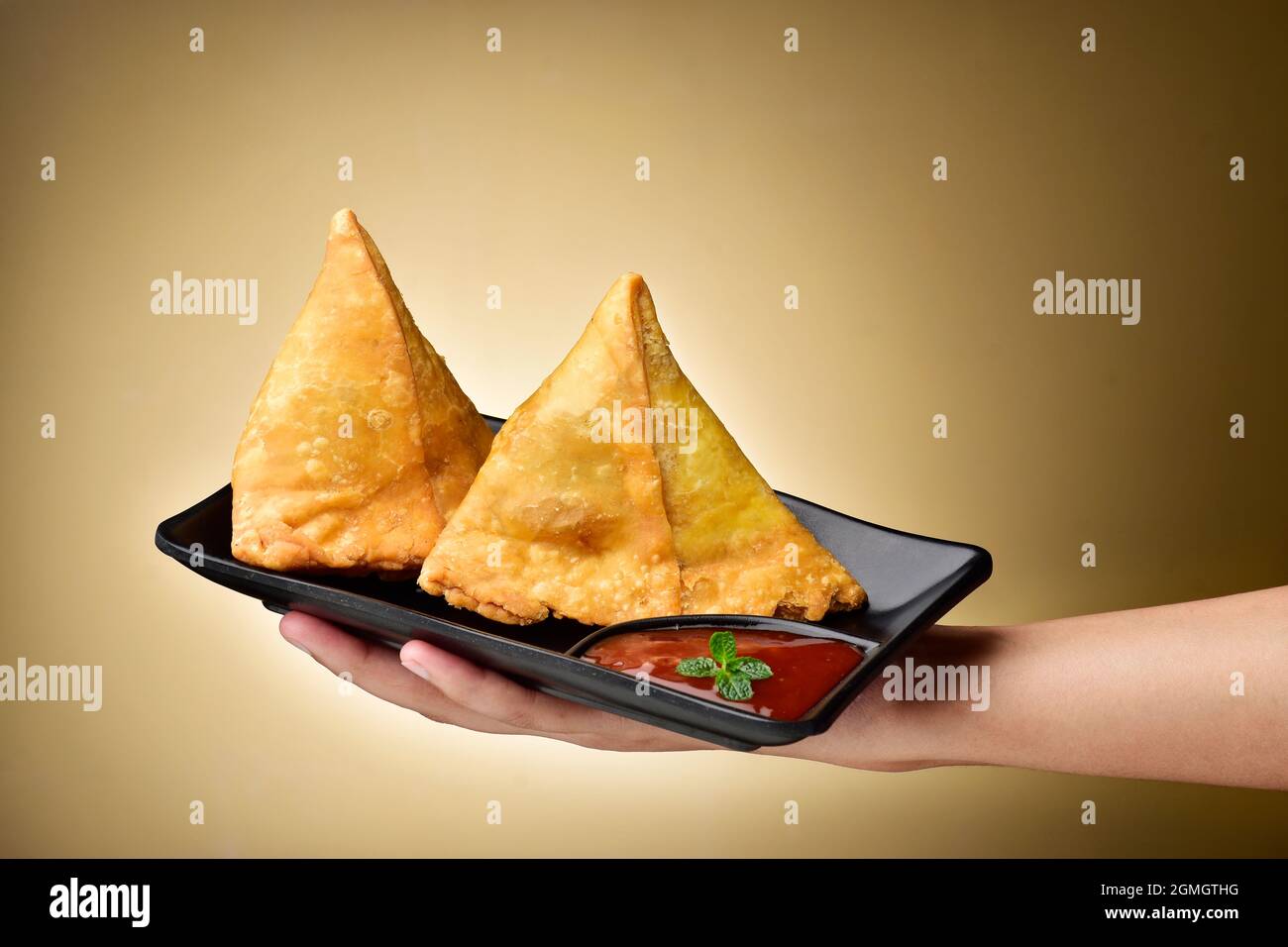 Samosa plate in hand, hand holding plate with samosa and tomato ketchup ...