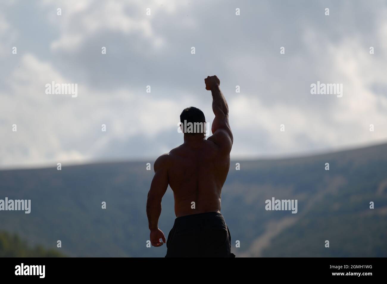 strong young male athlete lifting his arm hand up achieving success in ...