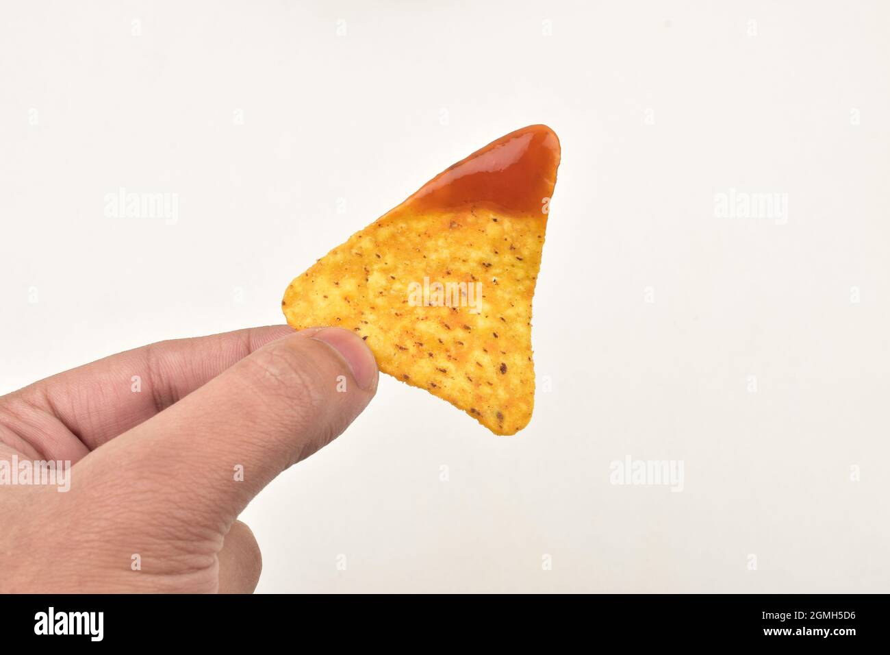 Single Nacho Chip in Hand Isolated on White Background Stock Photo - Alamy