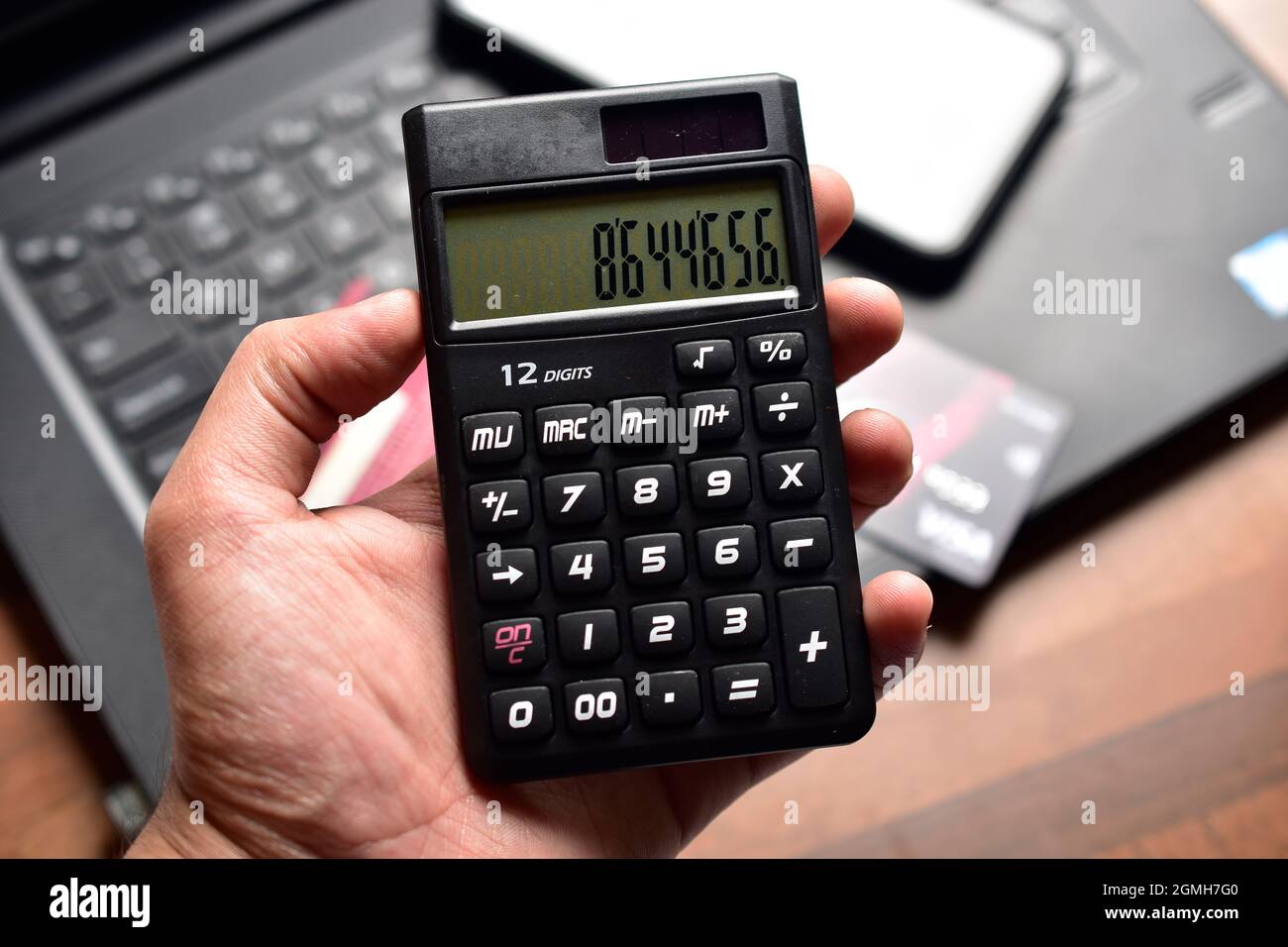Hand Holding Calculator doing Calculation Stock Photo - Alamy