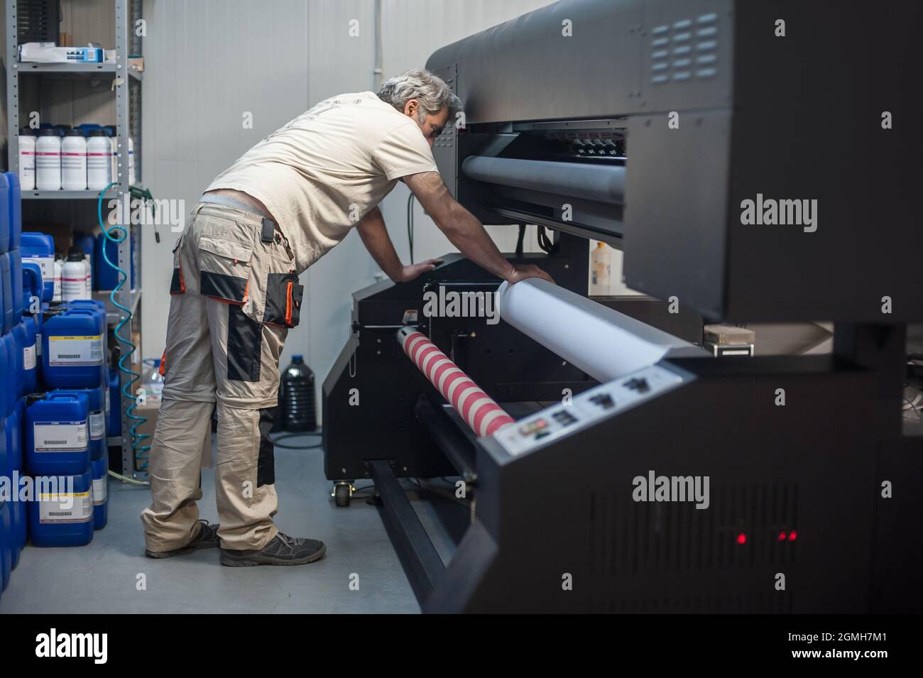 Technician worker operator changes the paper roll on large premium ...