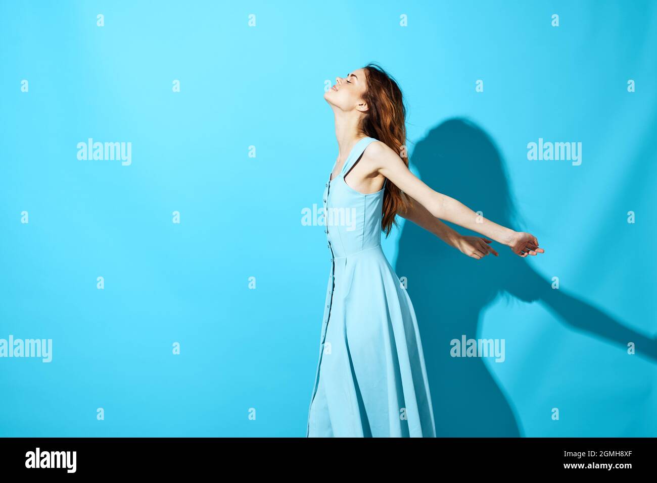 pretty woman in a blue dress hairstyle blue background Lifestyle Stock ...