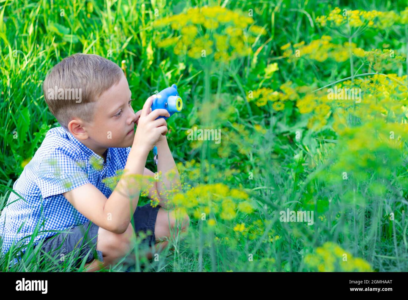 A cute preschool boy with a neat hairstyle in a blue shirt takes ...