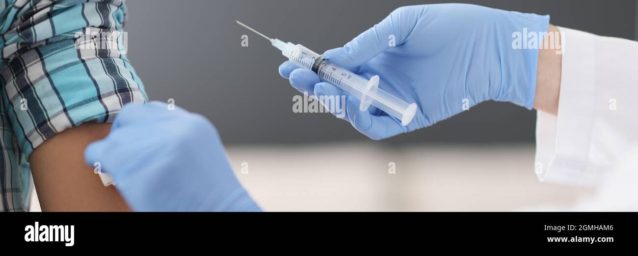 Nurse making injection of medicine into patient shoulder in clinic ...