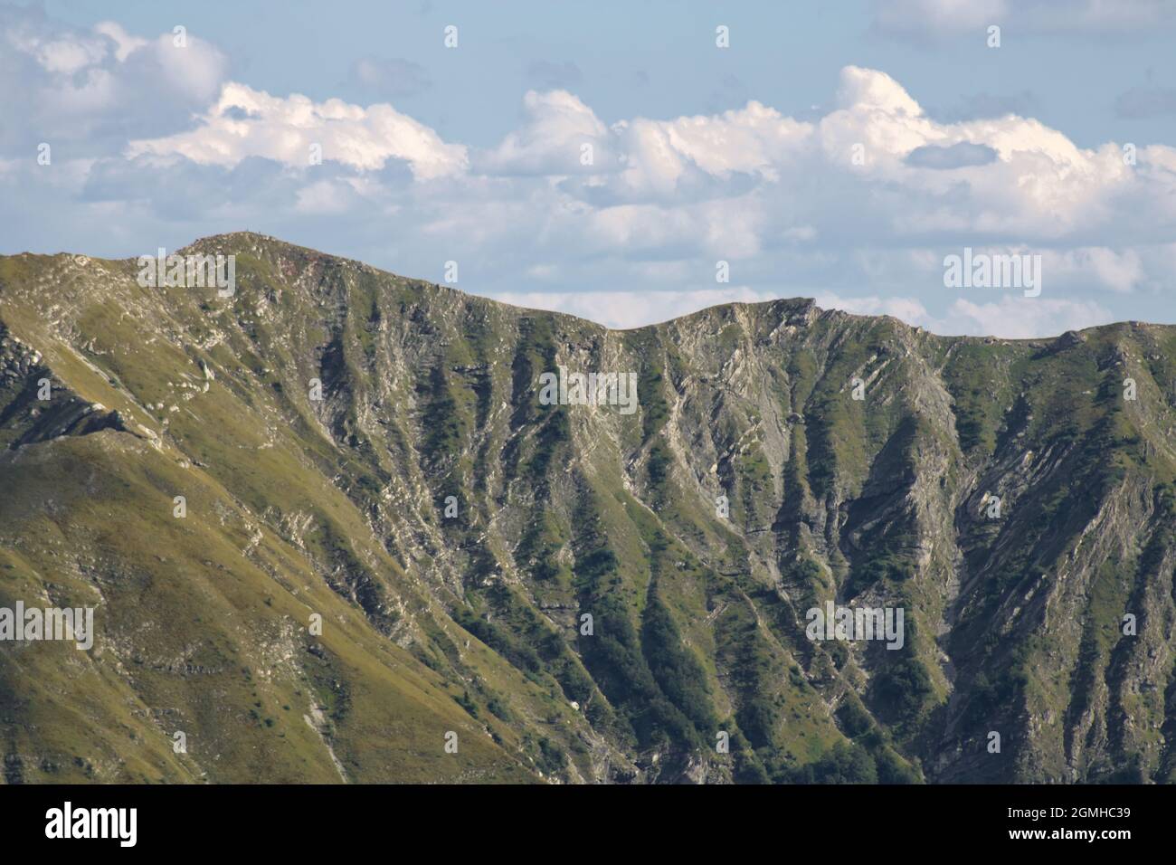 A high angle shot of mountainous landscape with peaks under sunlight ...