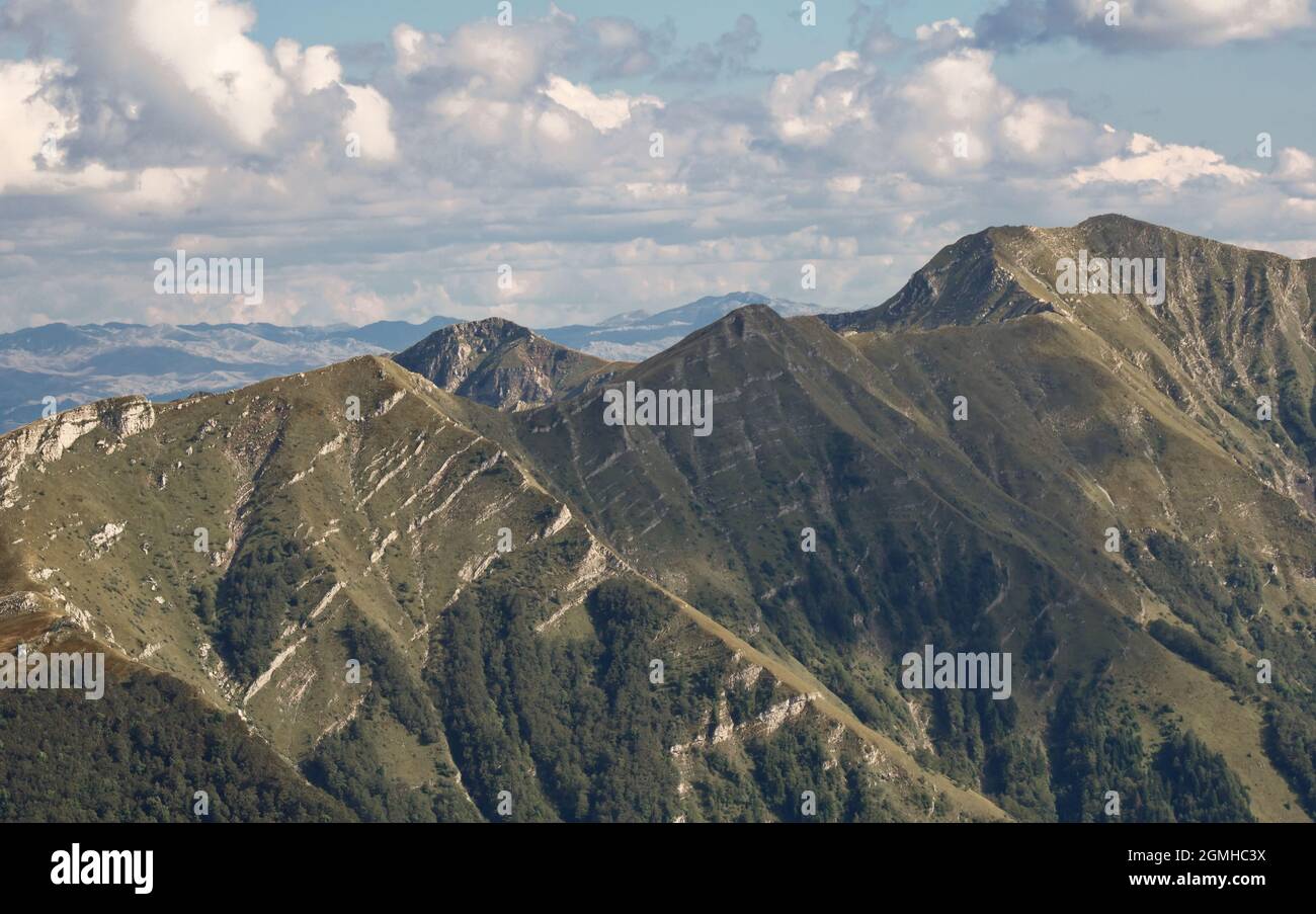 A high angle shot of mountainous landscape with peaks under sunlight ...