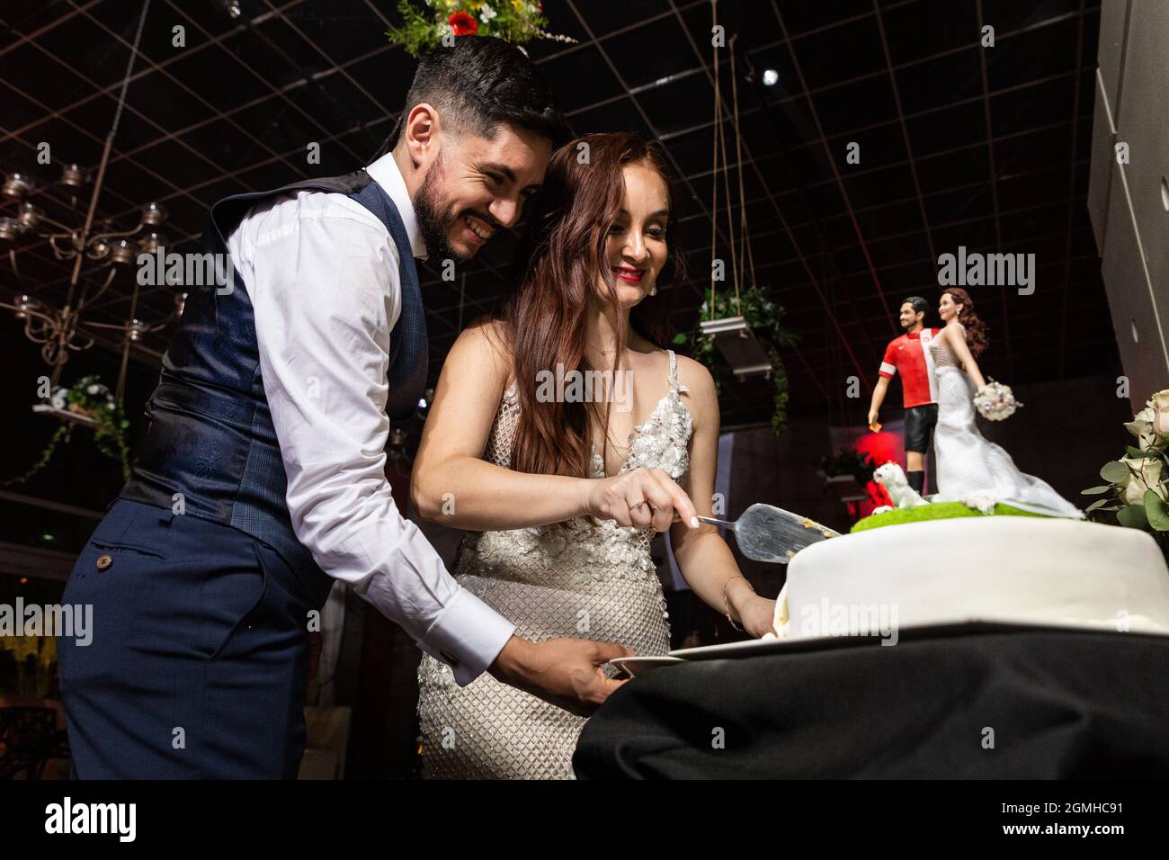 A beautiful scene of a newly married couple cutting the wedding cake ...
