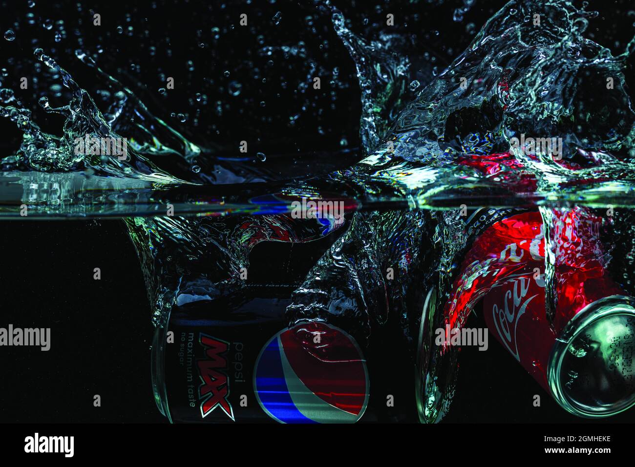 Close up view of coca cola and Pepsi cola falling in water on black ...