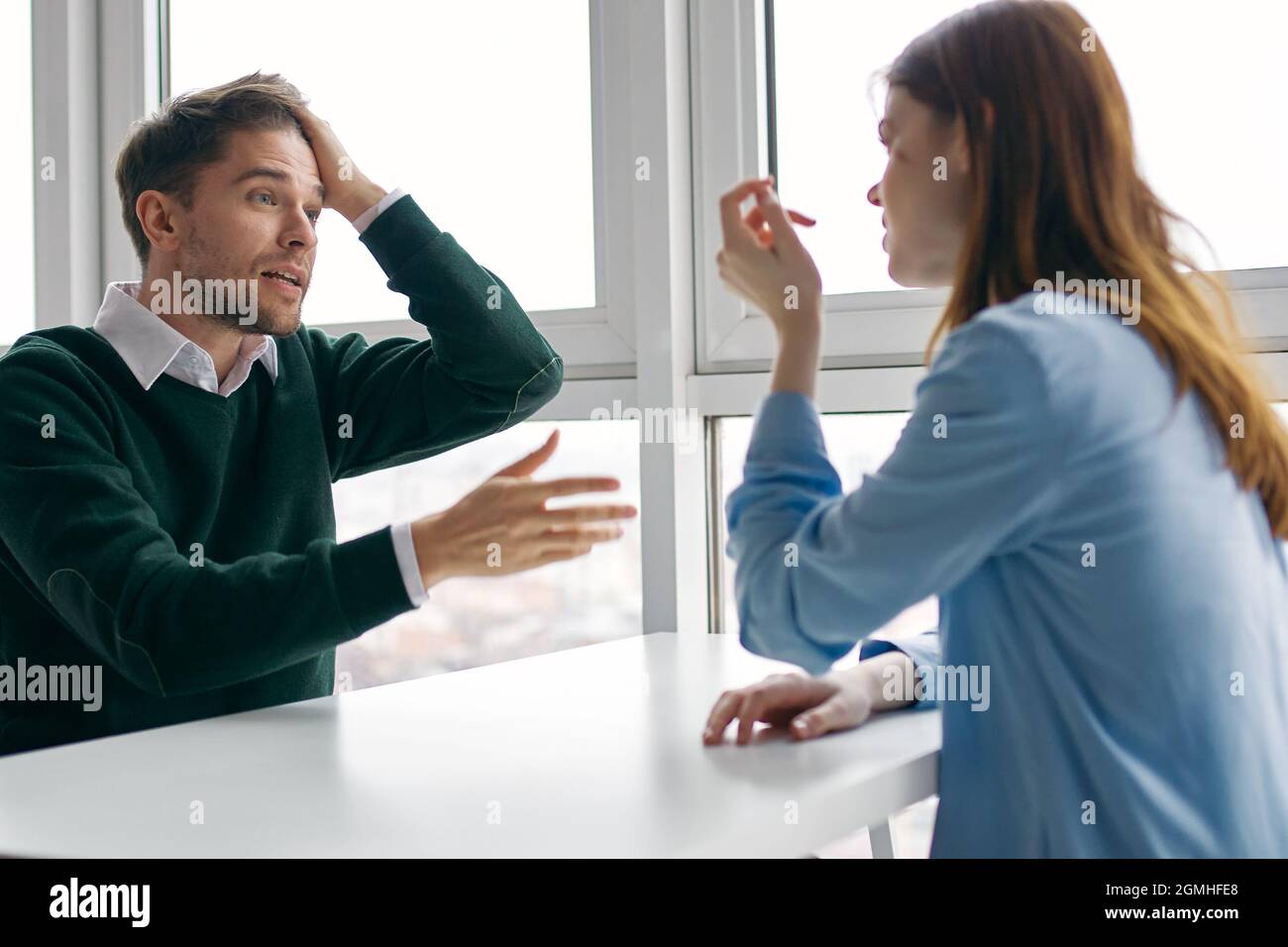 A Man And A Woman Sit At The Table And Communicate Opposite Each Other