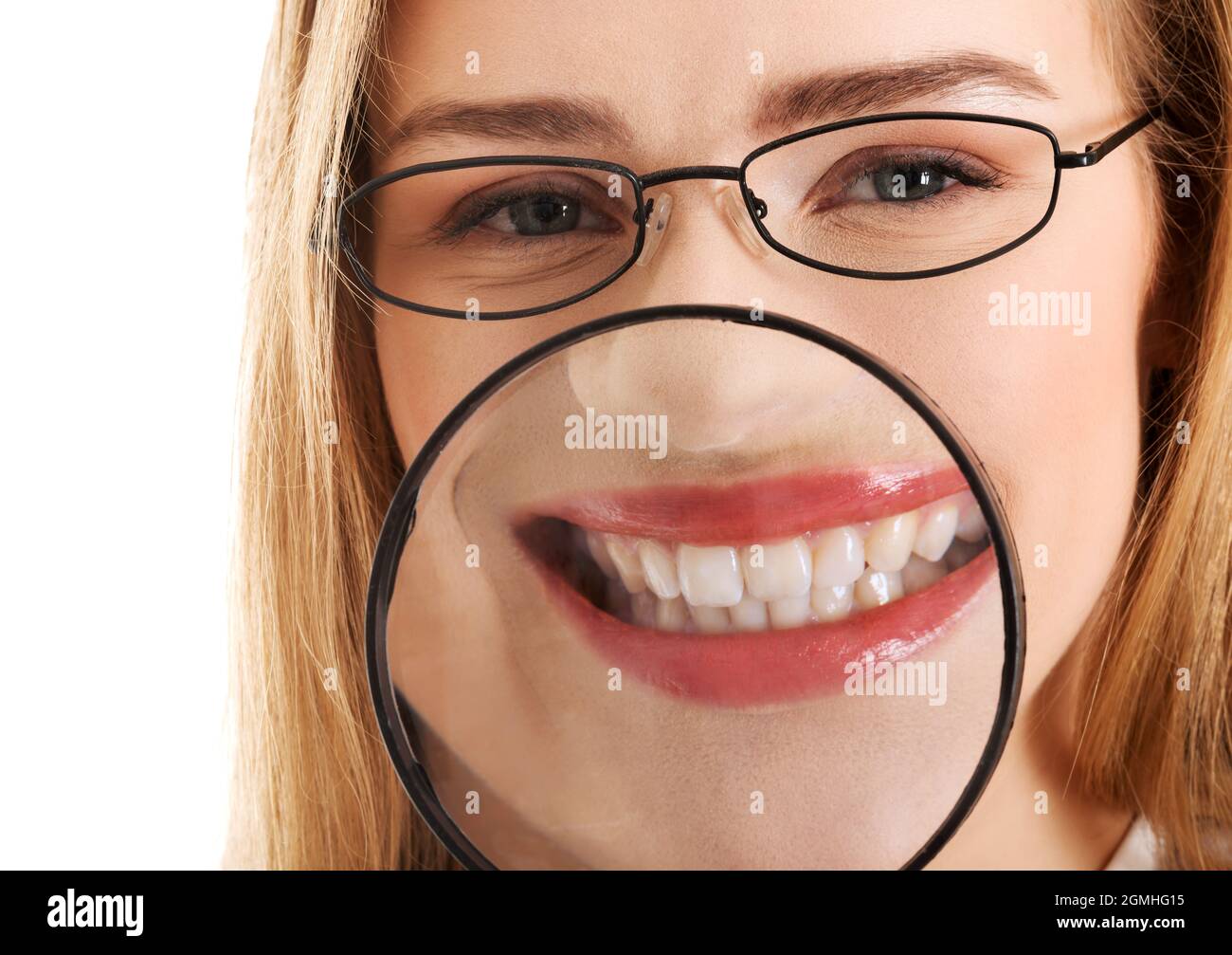 A blonde woman smiling with a magnifier on her teeth isolated on a ...