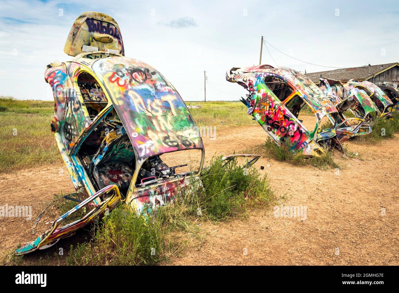 painted vintage type 1 Volkswagen Beetles half buried at an angle at ...