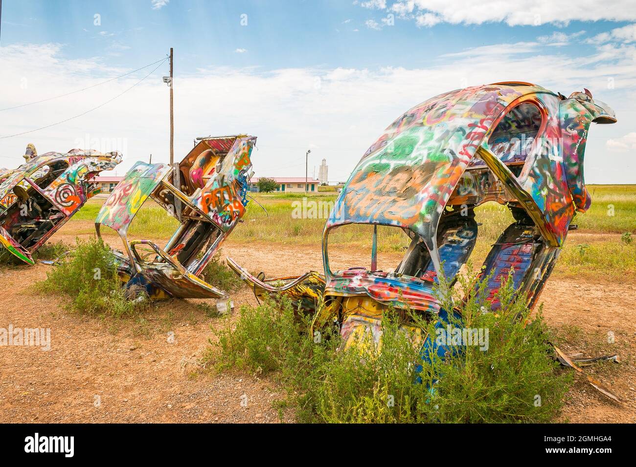 painted vintage type 1 Volkswagen Beetles half buried at an angle at ...