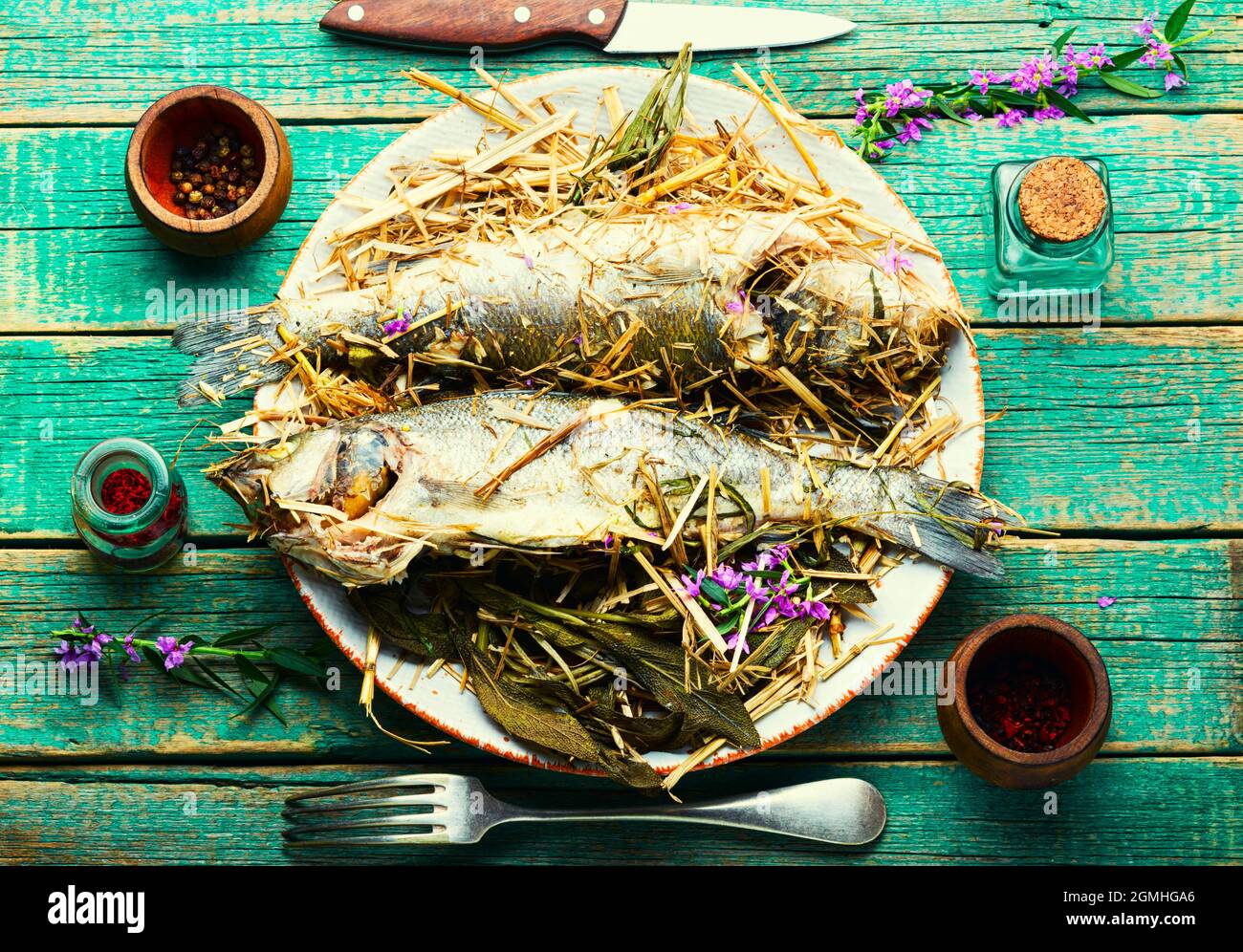 Fish baked in herbs and meadow hay. Roasted sea bass with spicy herbs ...