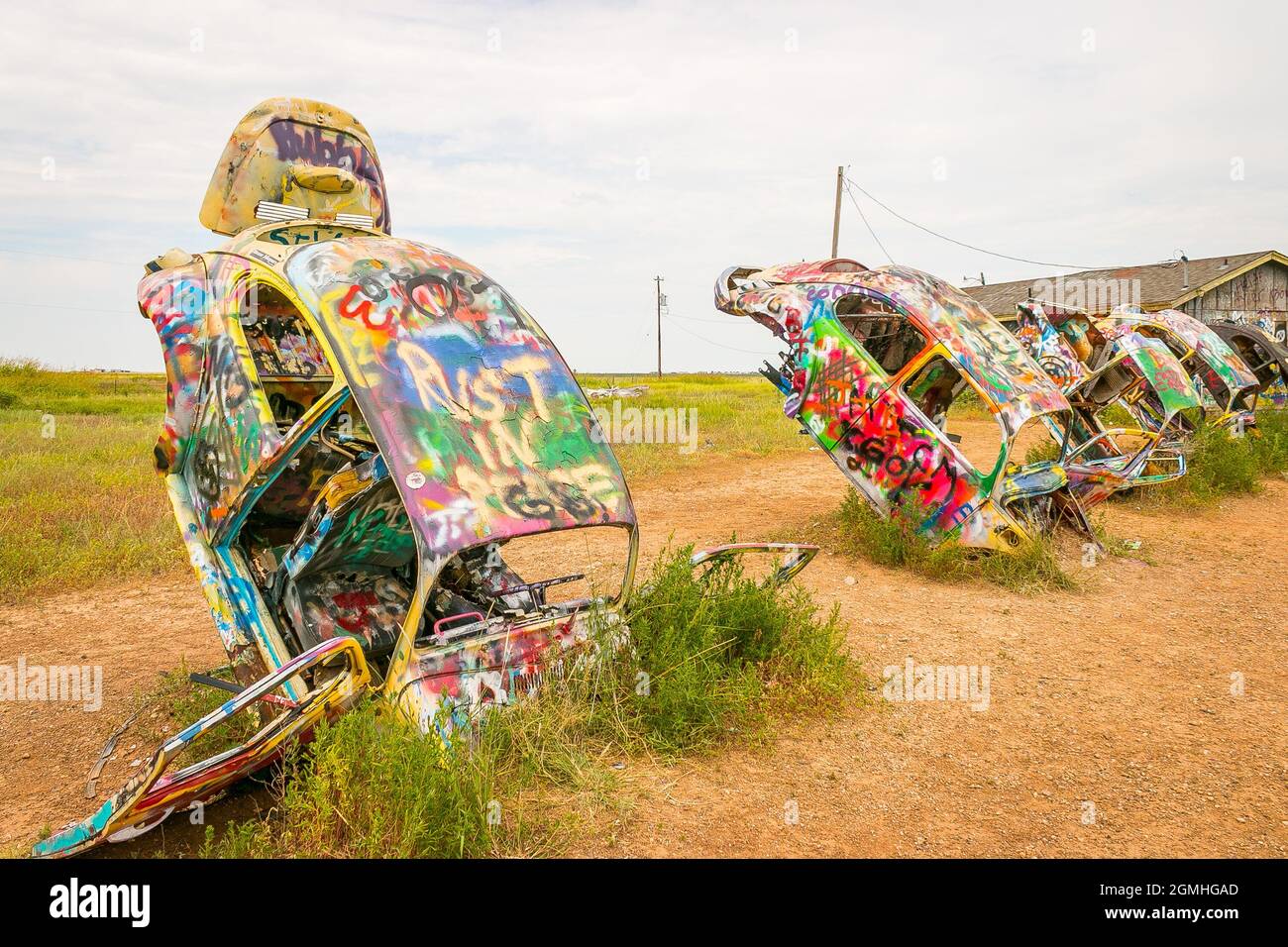 painted Volkswagen Beetles half buried at an angle at Slug Bug Ranch ...