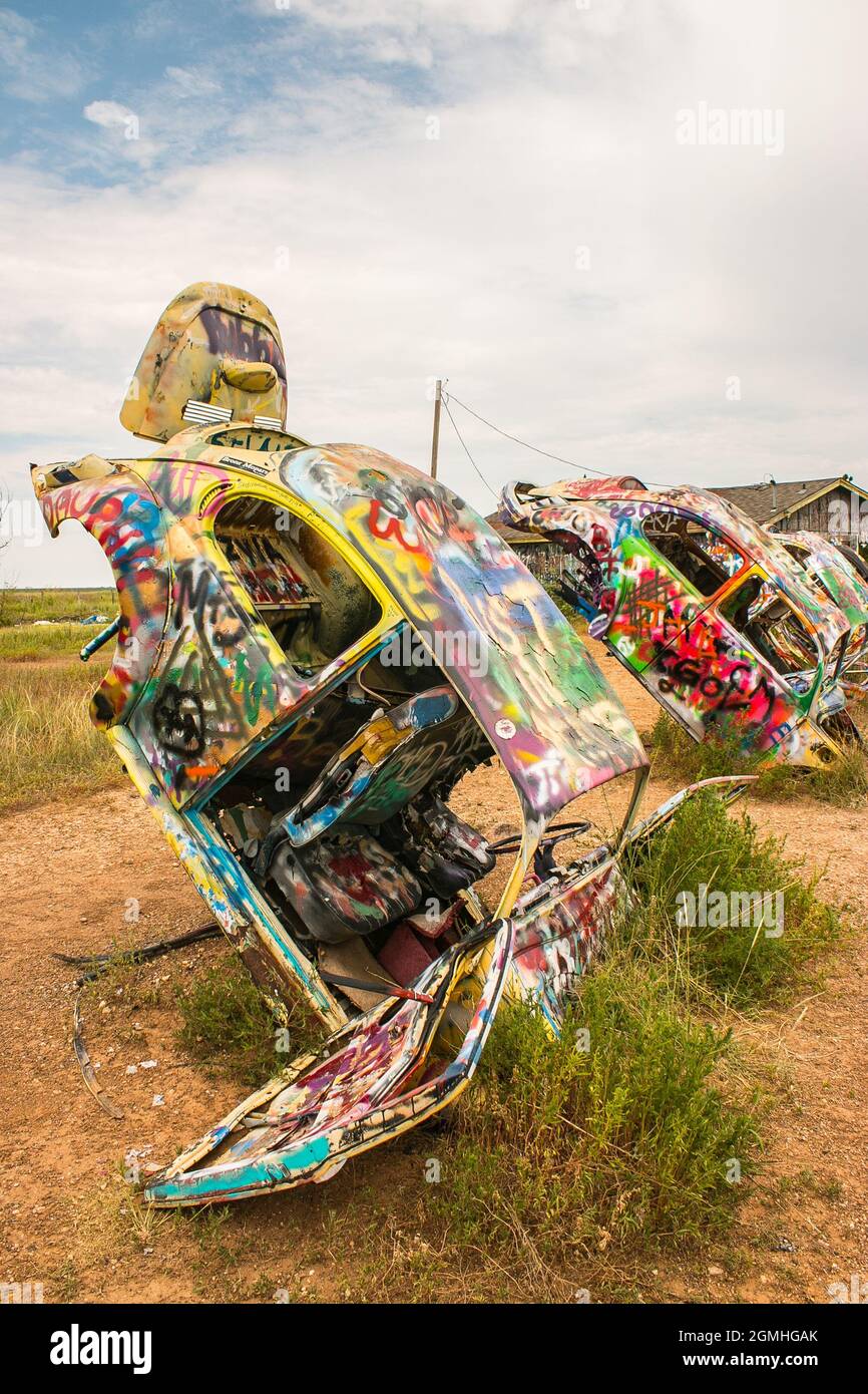 painted Volkswagen Beetles half buried at an angle at Slug Bug Ranch ...