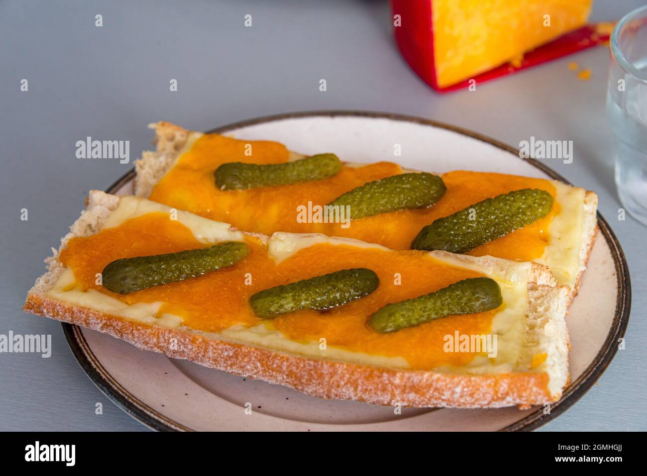 melted cheddar cheese on french bread with gerkin topping Stock Photo ...