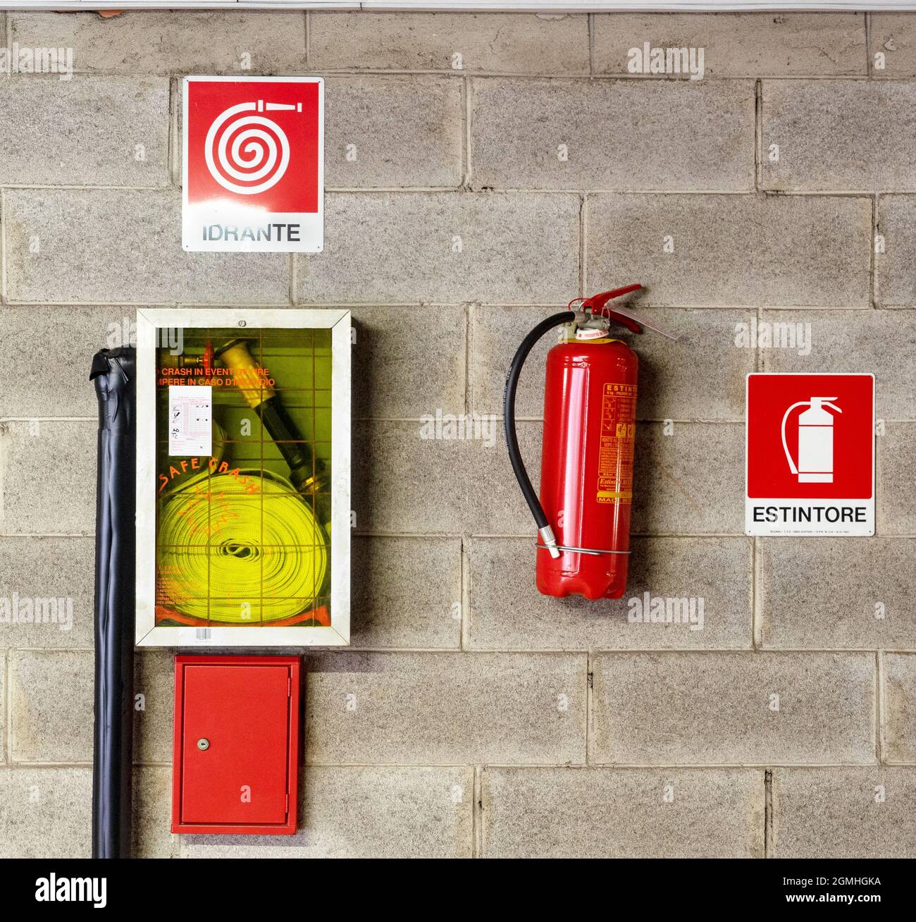 hydrant and fire extinguisher with relative signs hanging on the wall ...