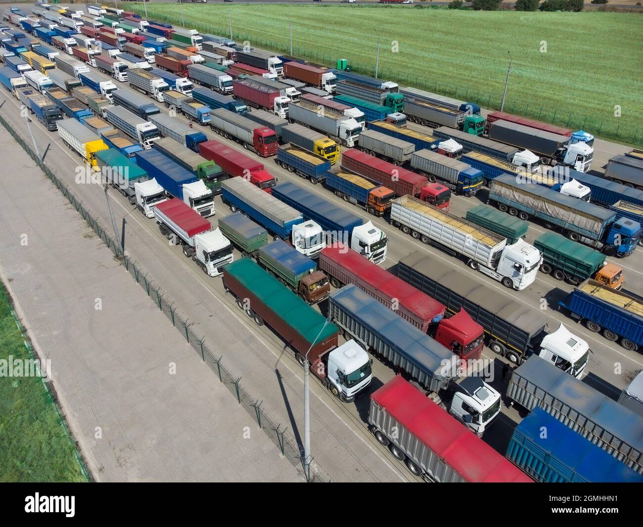 Trucks in line in the parking lot to the terminal in the port. Aerial ...