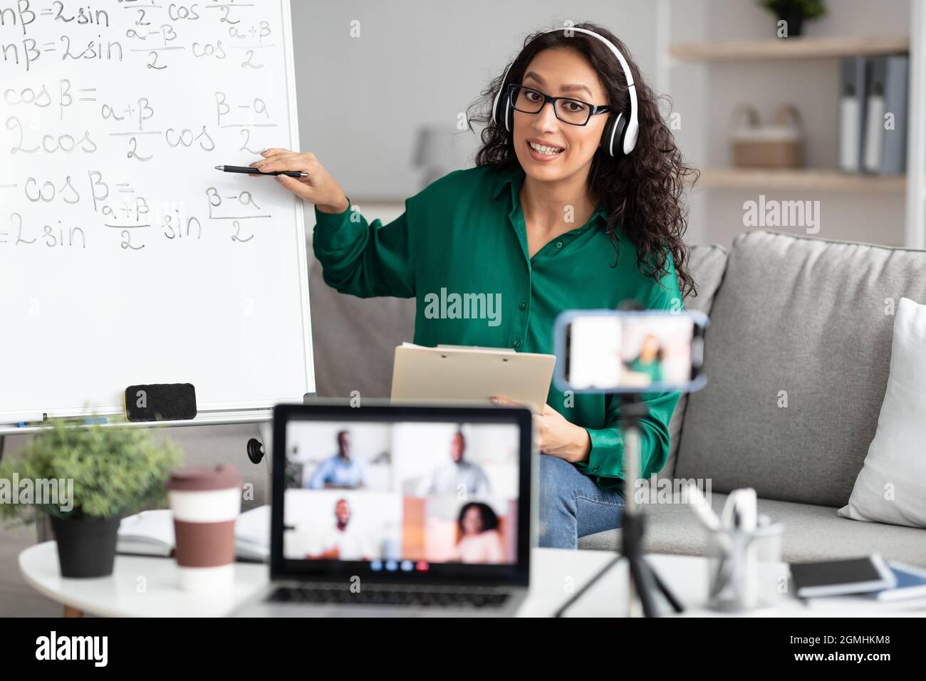 Young teacher showing board, giving virtual lecture to diverse students ...