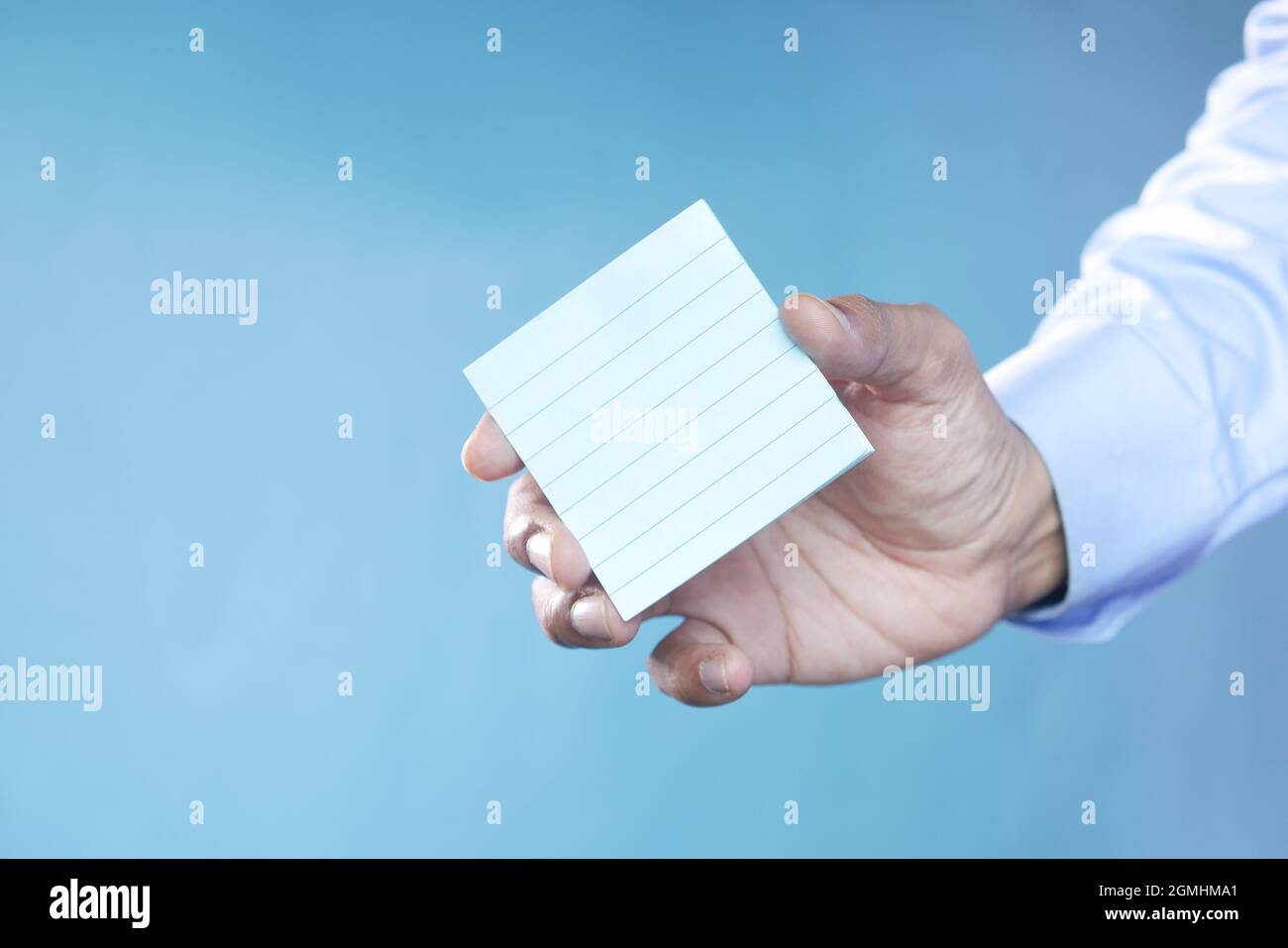 man hand hold a sticky note against blue background Stock Photo - Alamy