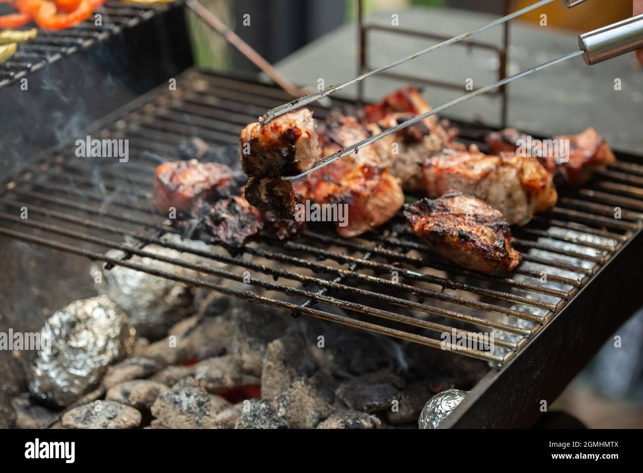 A barbecue grill with tasty juicy steaks are grilled over an open fire ...