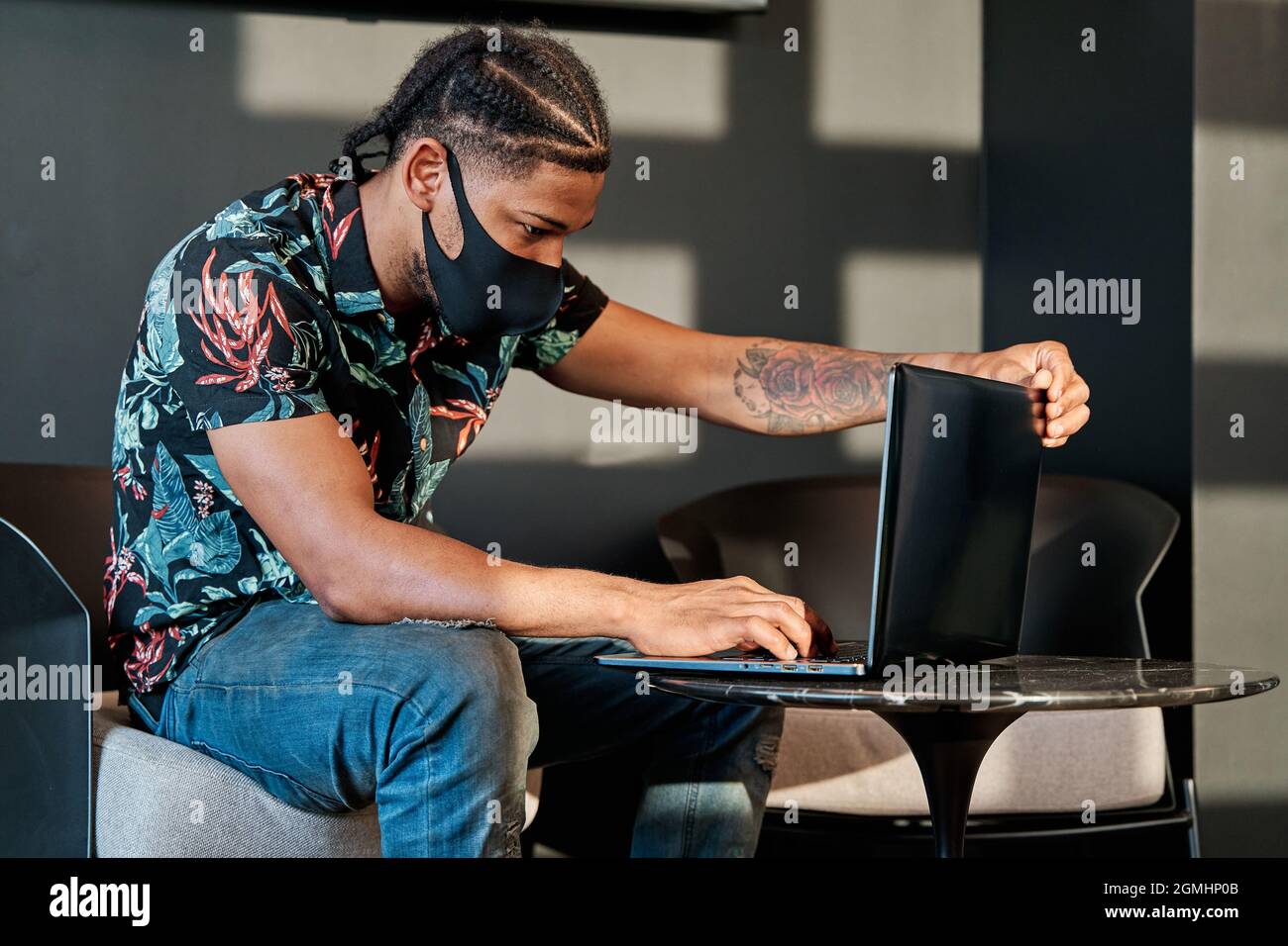 A young Latin man working with his laptop from home Stock Photo - Alamy