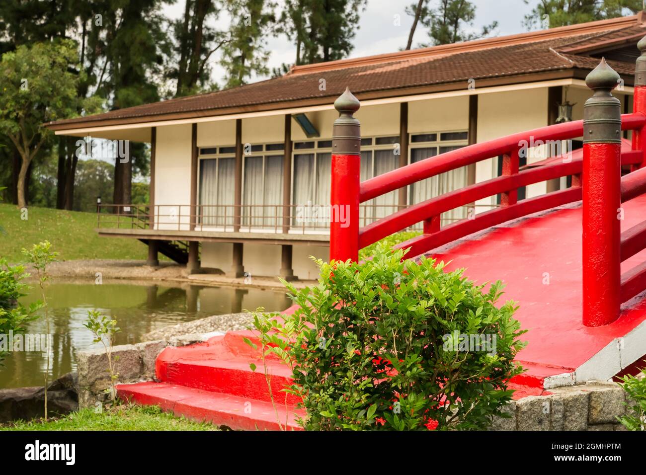 A wooden bridge across a small river in front of a traditional house ...