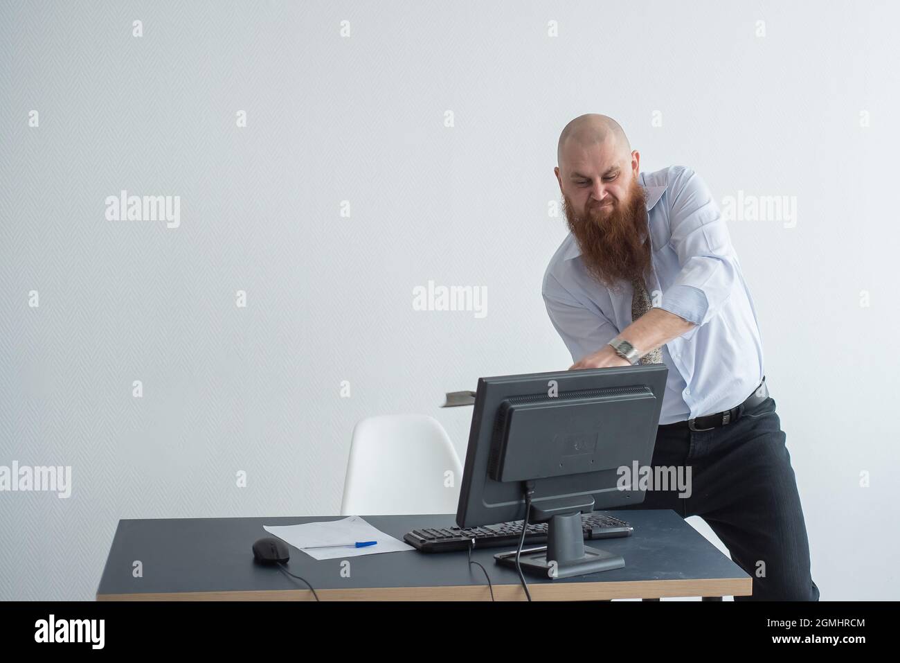 Stressed crazy businessman smashing his computer in office using ax ...