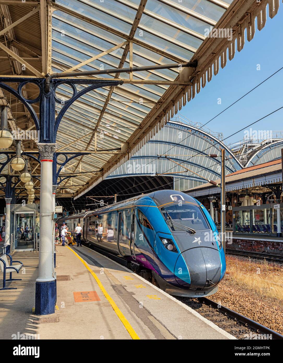 A modern locomotive stands at railway station platform. A 19th century ...