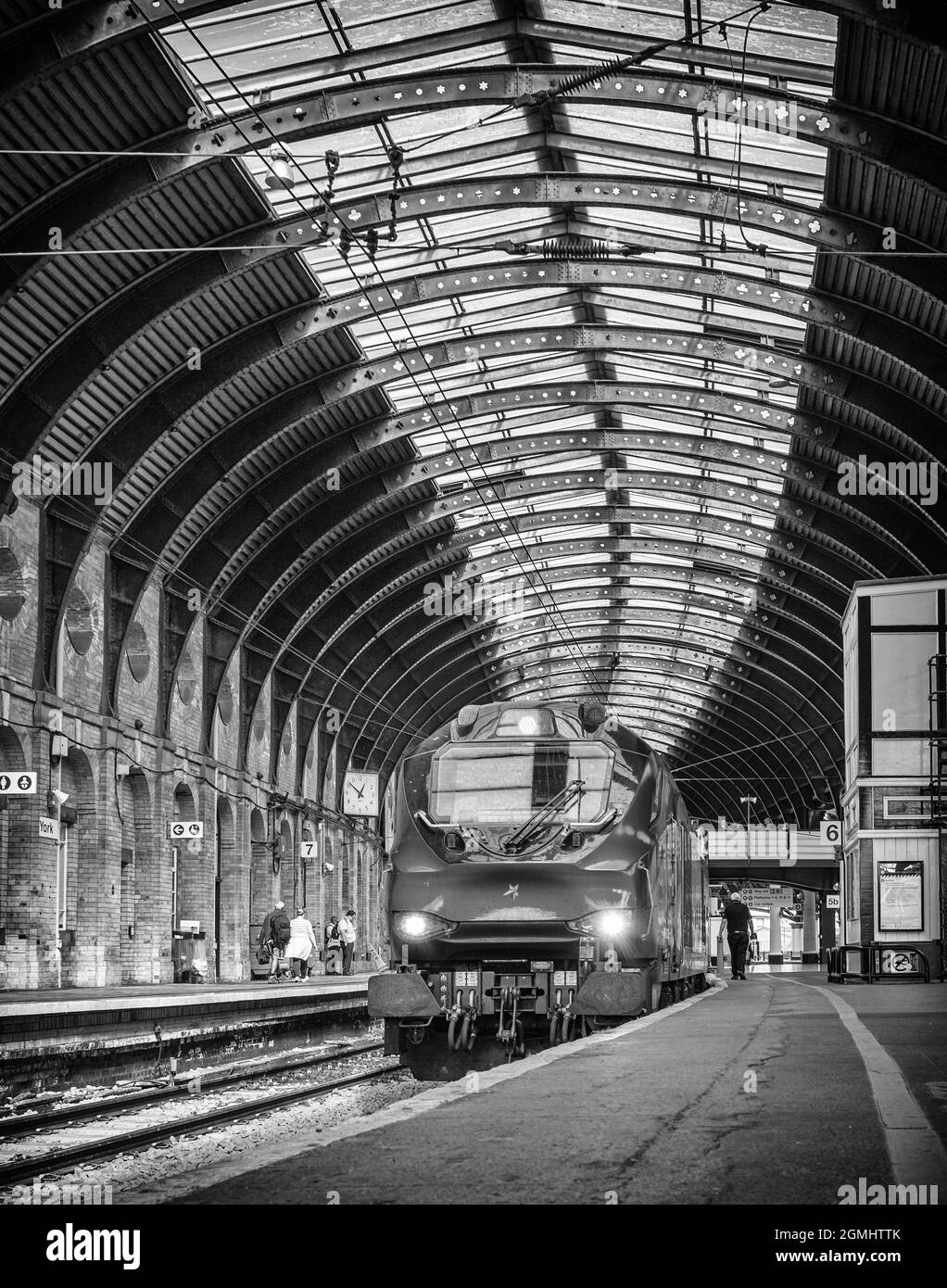 A modern and angled locomotive with its lights switched on, stands ...