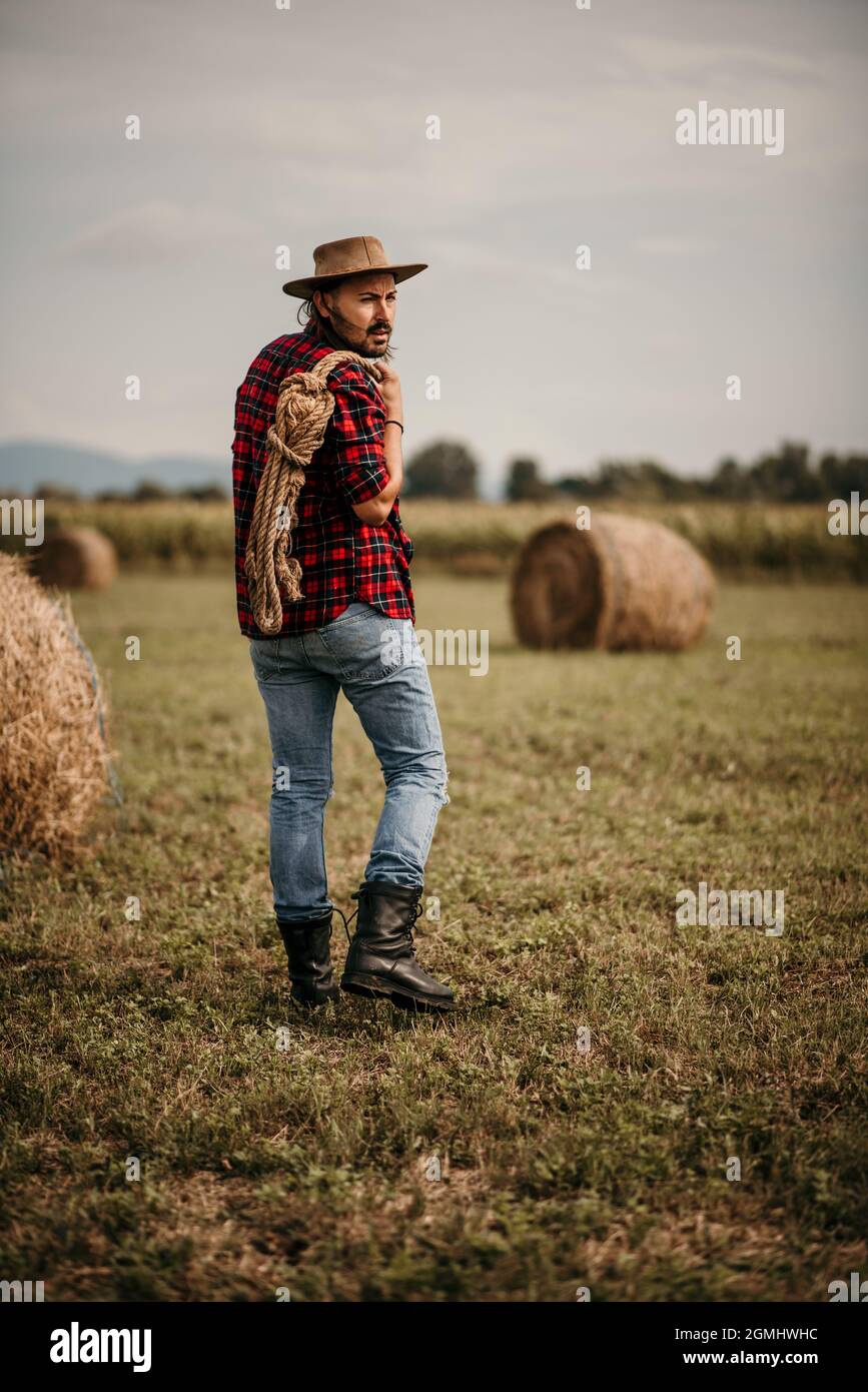 A young handsome Serbian male in a flannel shirt with ropes in his ...