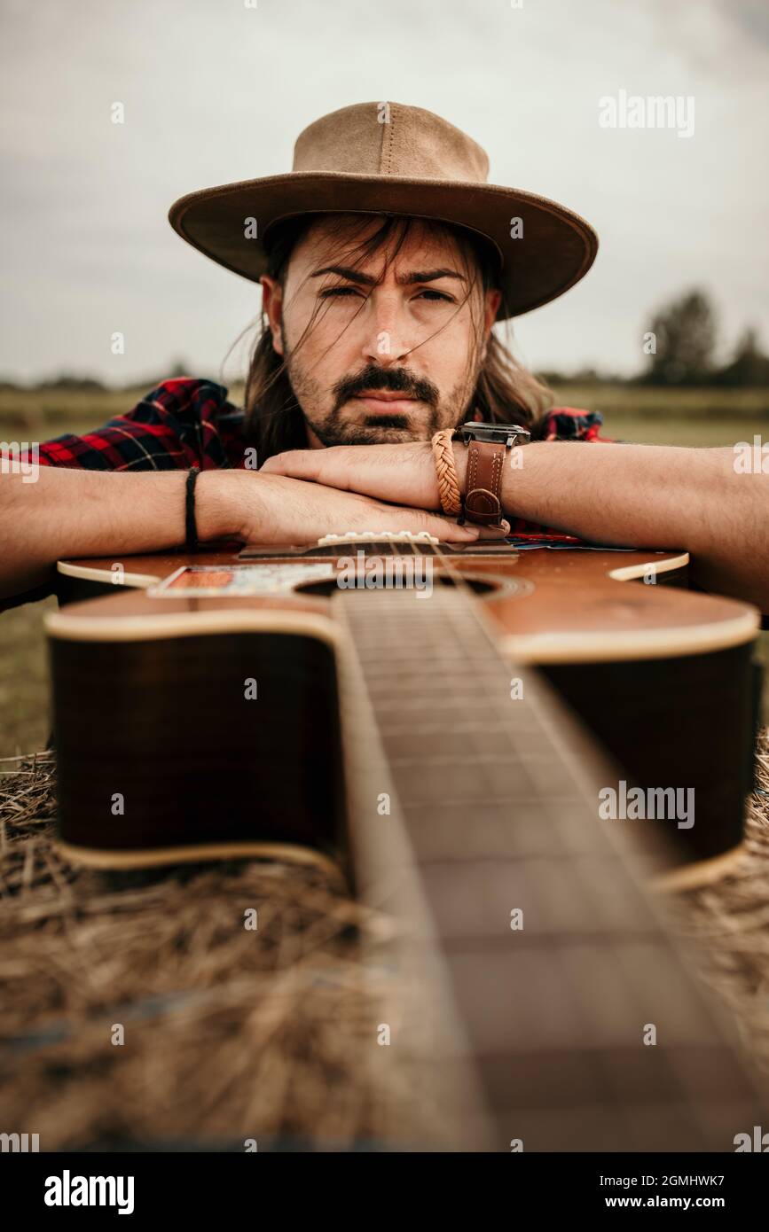 A young handsome Serbian male in a flannel shirt with an acoustic ...