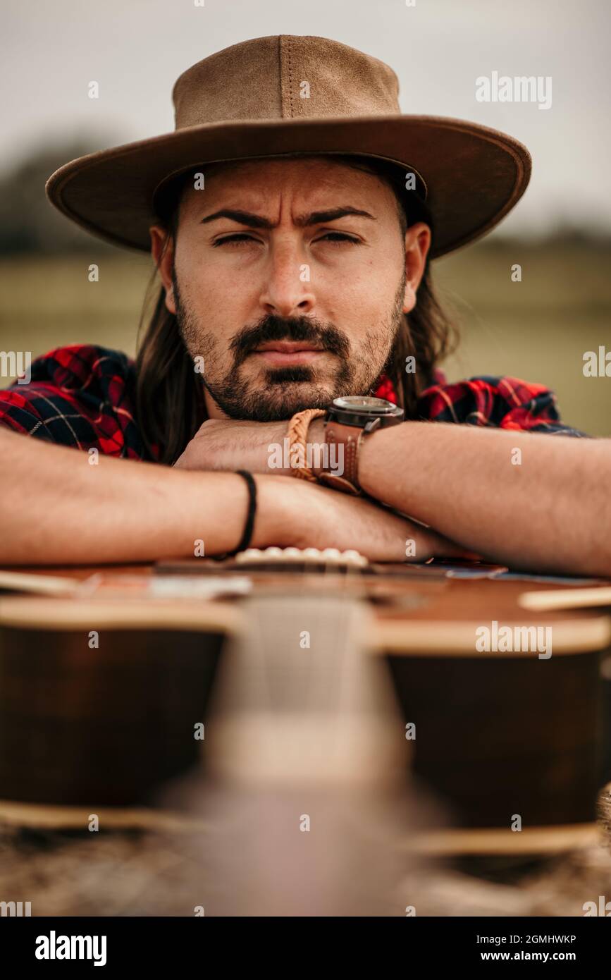 A young handsome Serbian male in a flannel shirt with an acoustic ...