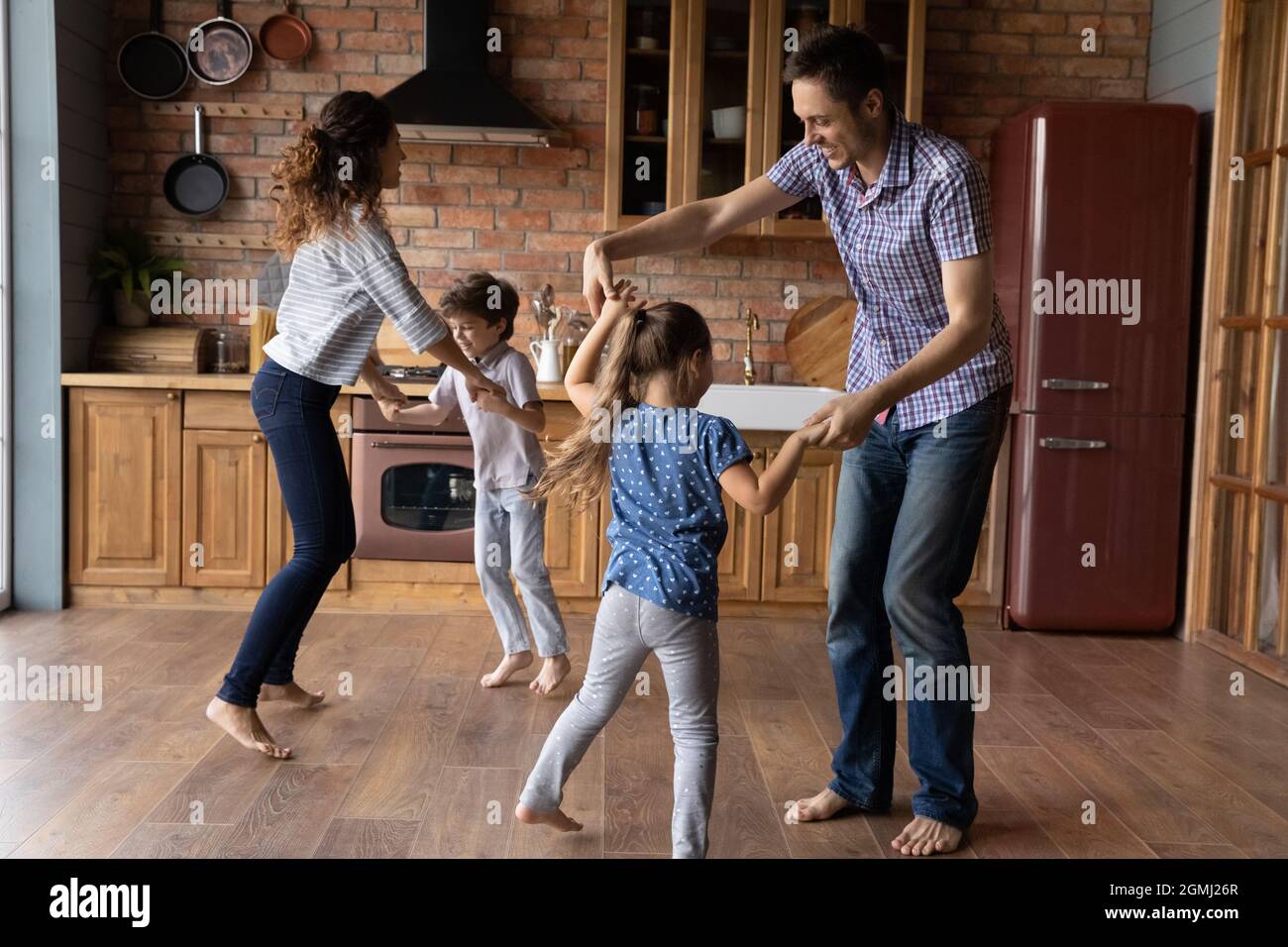 Happy couple parents dancing with cute children at home Stock Photo - Alamy