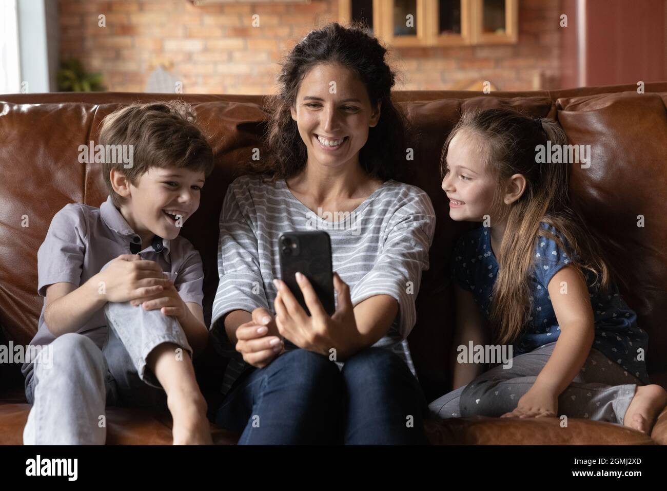 Happy young mother using cellphone with kids Stock Photo - Alamy