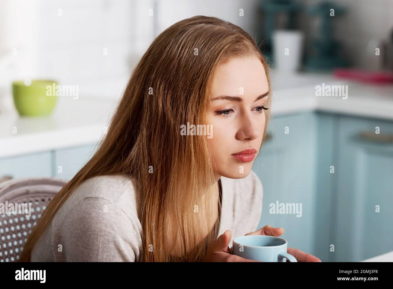 A sad depressed young female drinking coffee in the morning Stock Photo ...