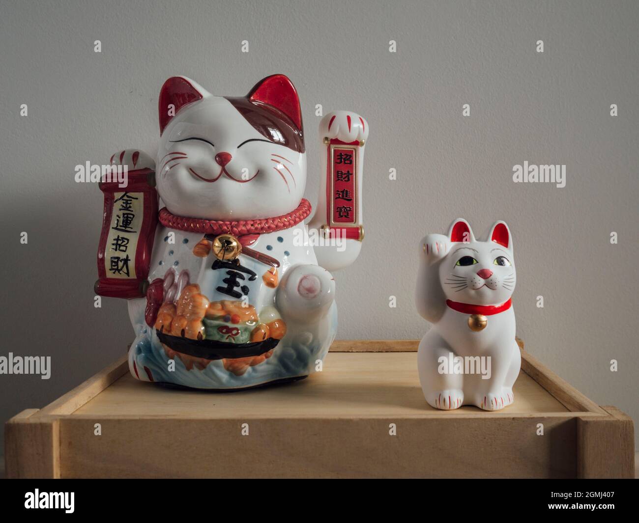 Pair of asian fortune cats on a wooden crate Stock Photo - Alamy