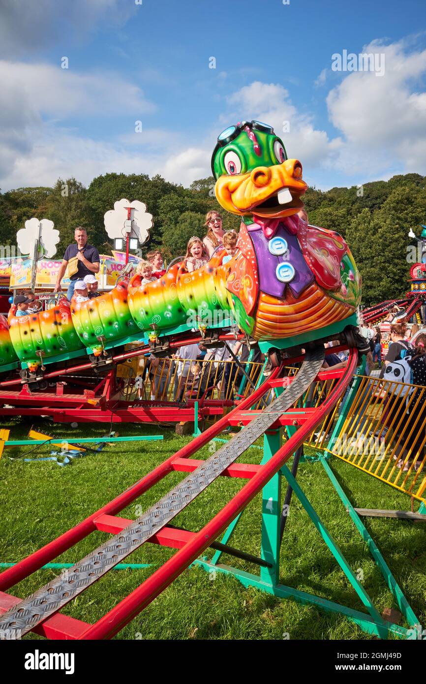 Riding a colourful dragon children's fair ground ride Stock Photo - Alamy