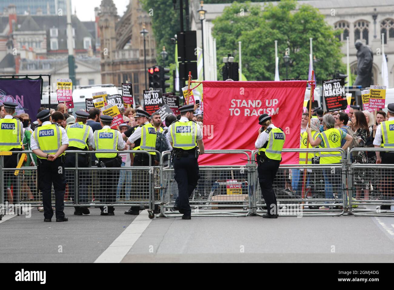 Police constables on duty at a barrier keeping a crowd of protestors ...