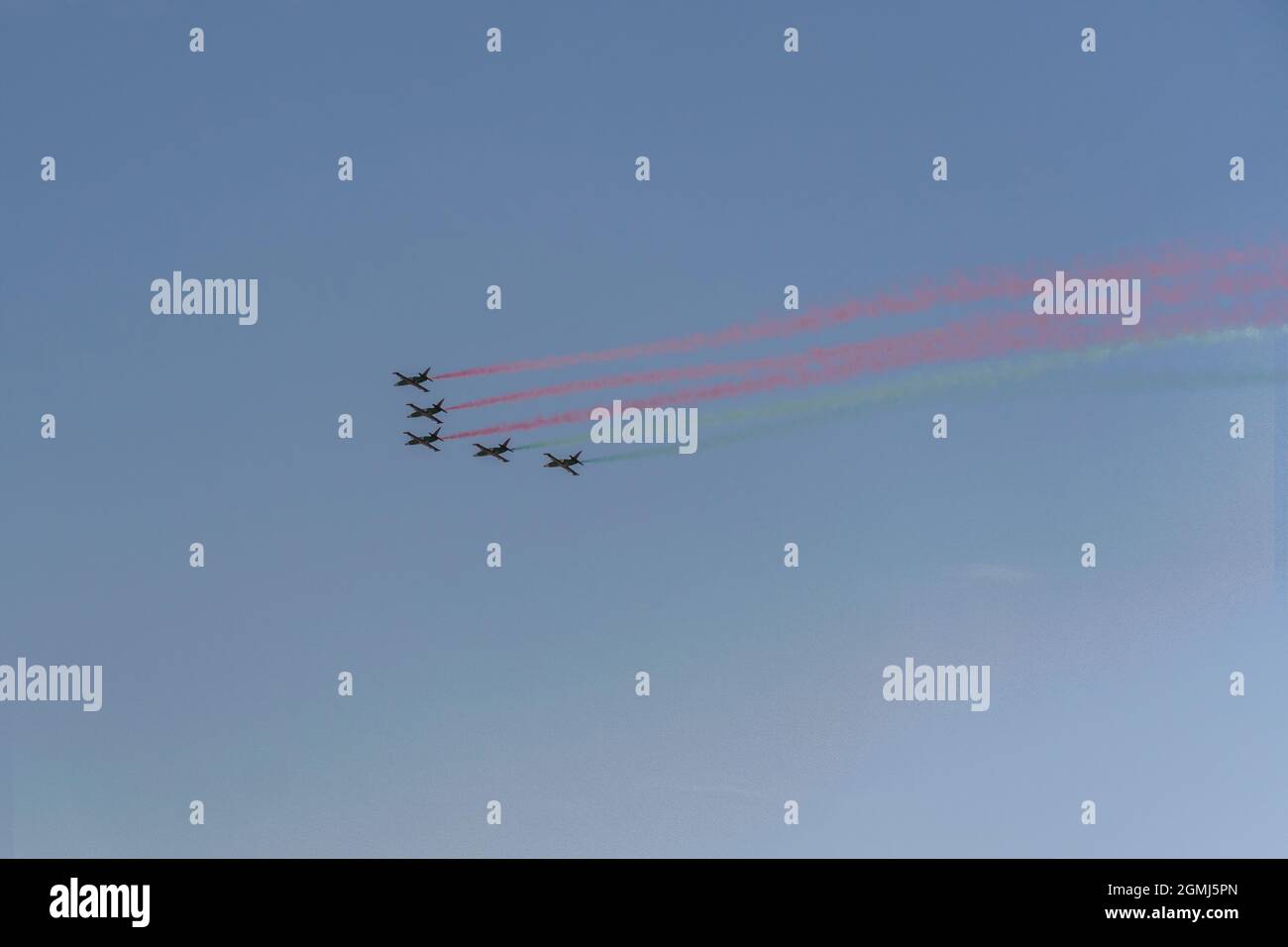 five planes fly across the sky and leave colorful streaks of smoke ...