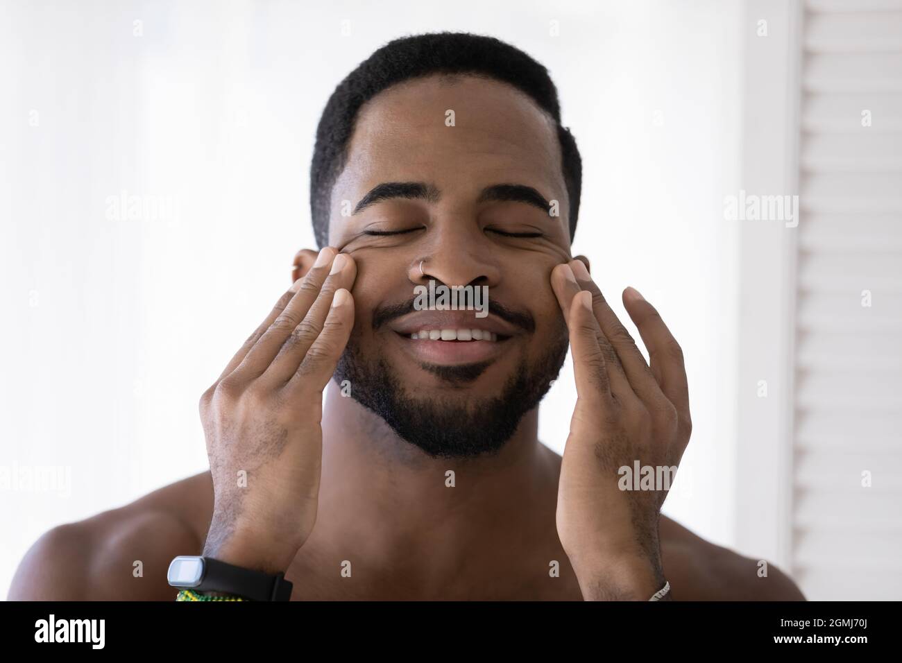 Handsome African man touch face massages smooth perfect skin Stock ...