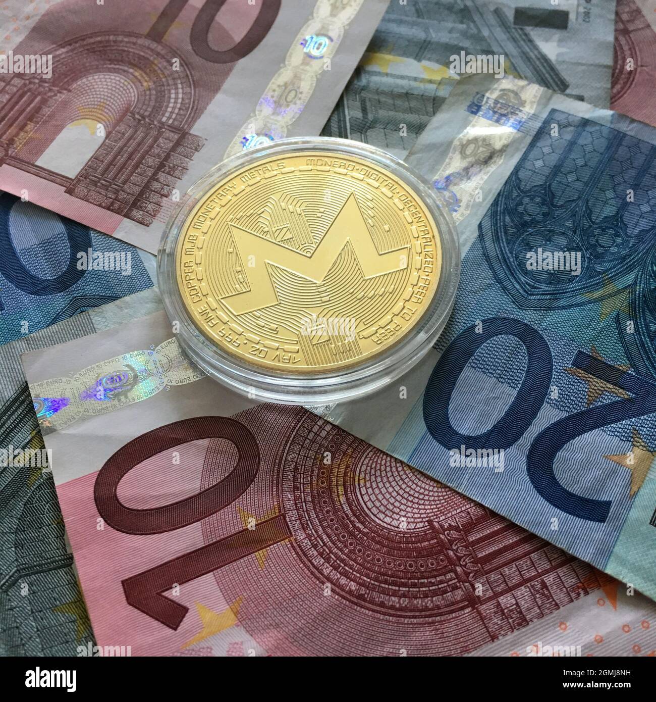 A top view of a Monero golden coin on a pile of euros Stock Photo - Alamy